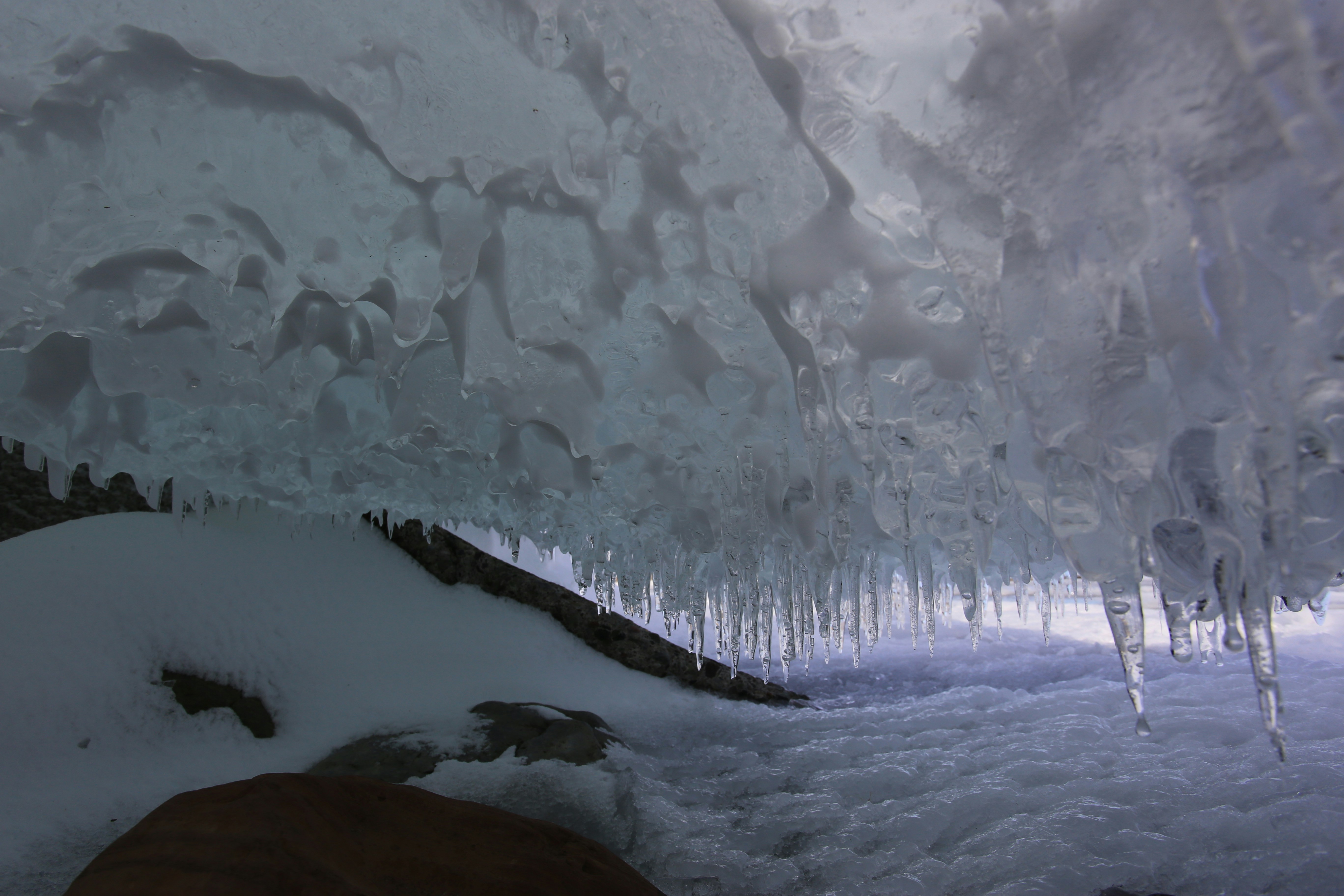 A large ice cave with icicles hanging from the ceiling photo – Free ...
