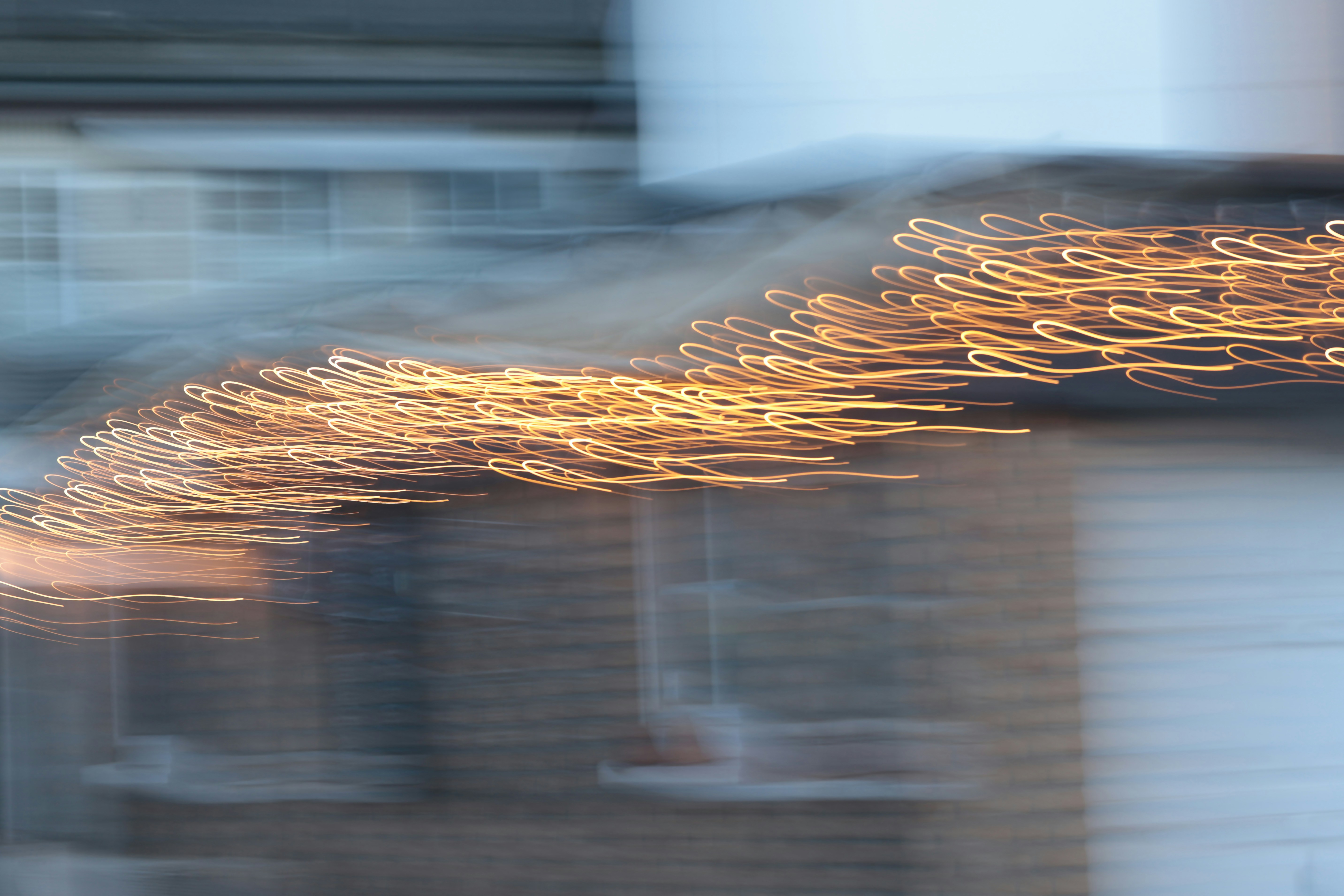 Warm string lights create a dynamic blur against a softly lit backdrop, conveying a sense of movement and festivity.
