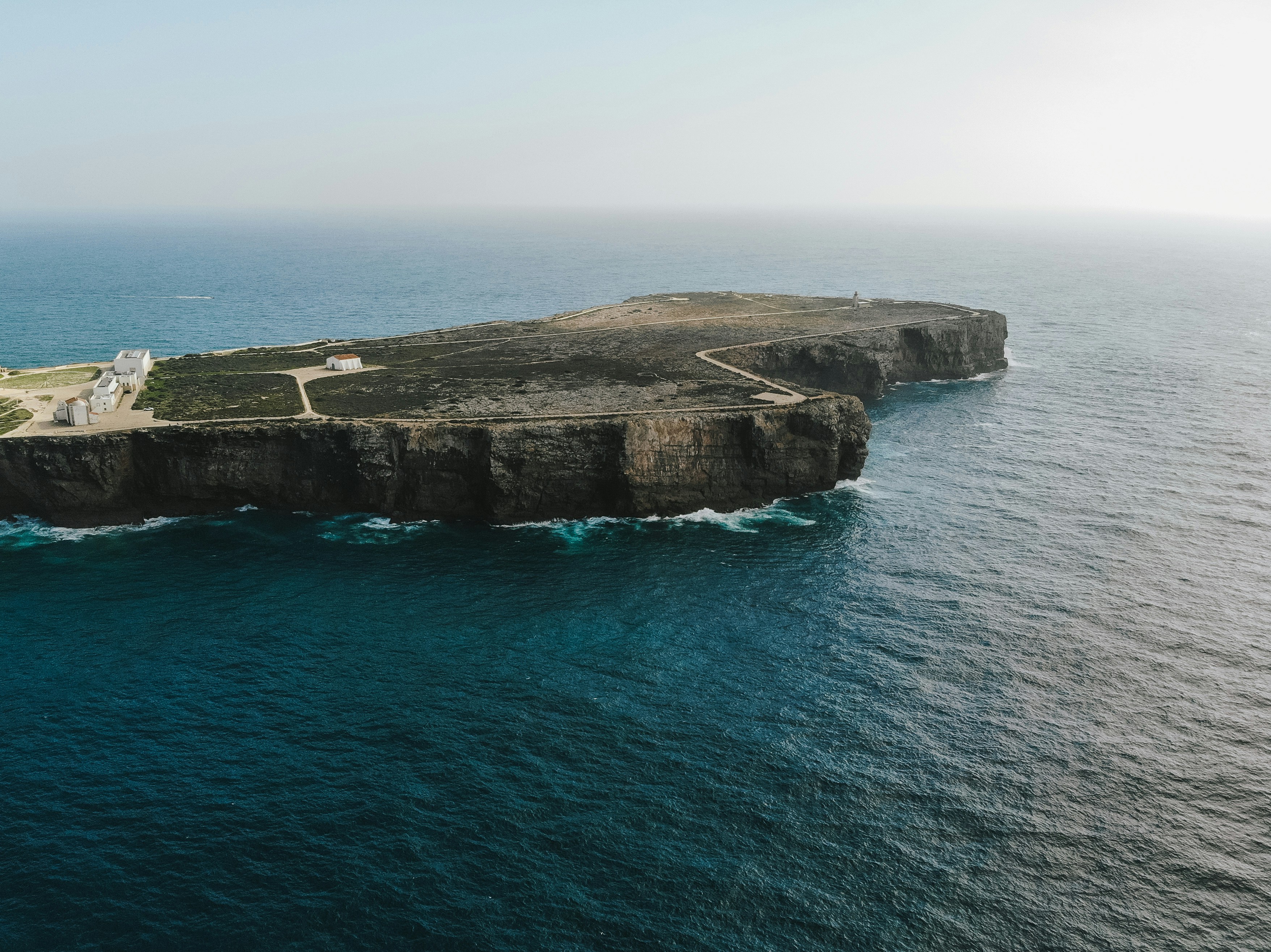 Aerial view of Sagres Fortress perched on rugged cliffs surrounded by the Atlantic Ocean.