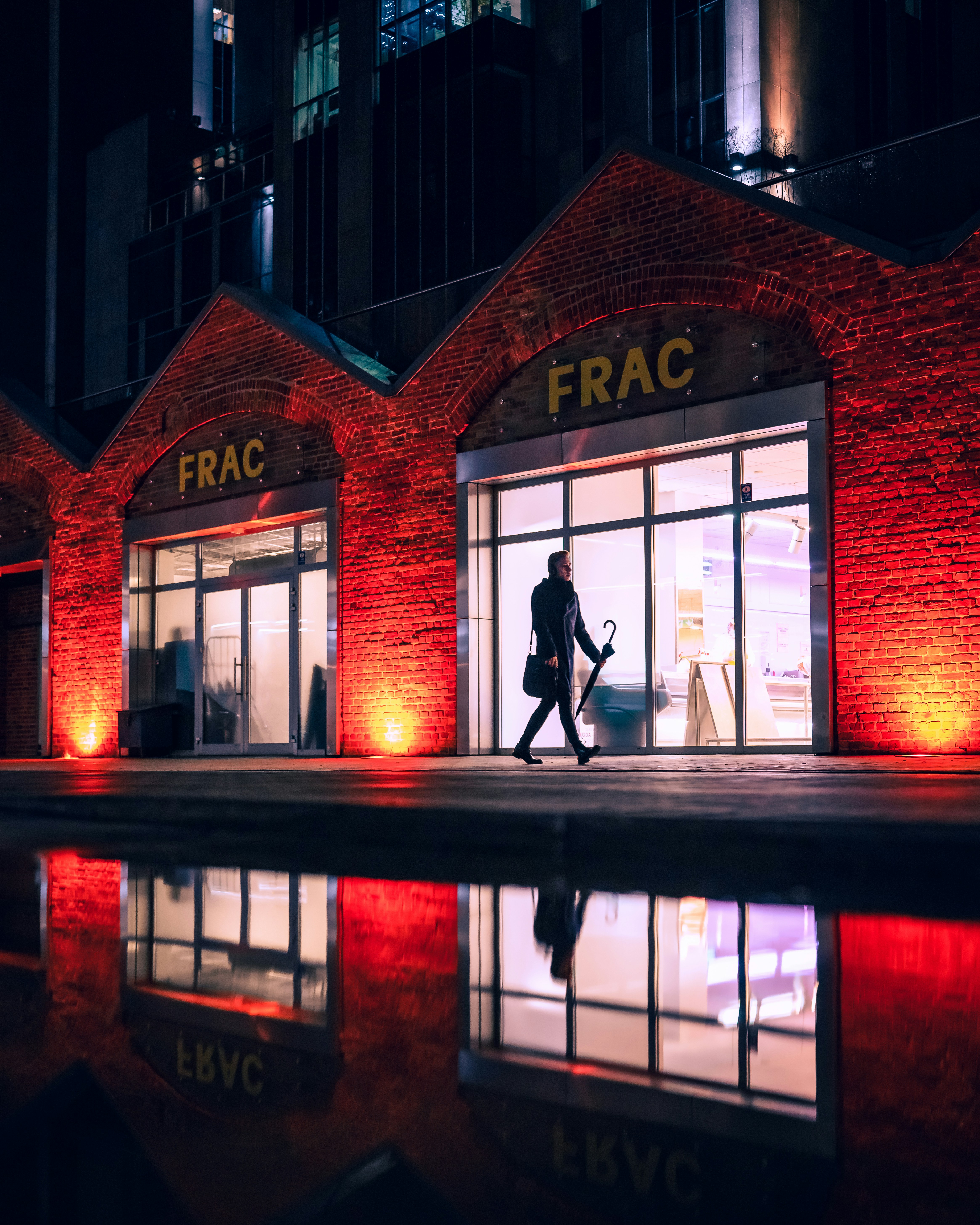 A person walking out of a building at night photo – Free Warszawa Image ...