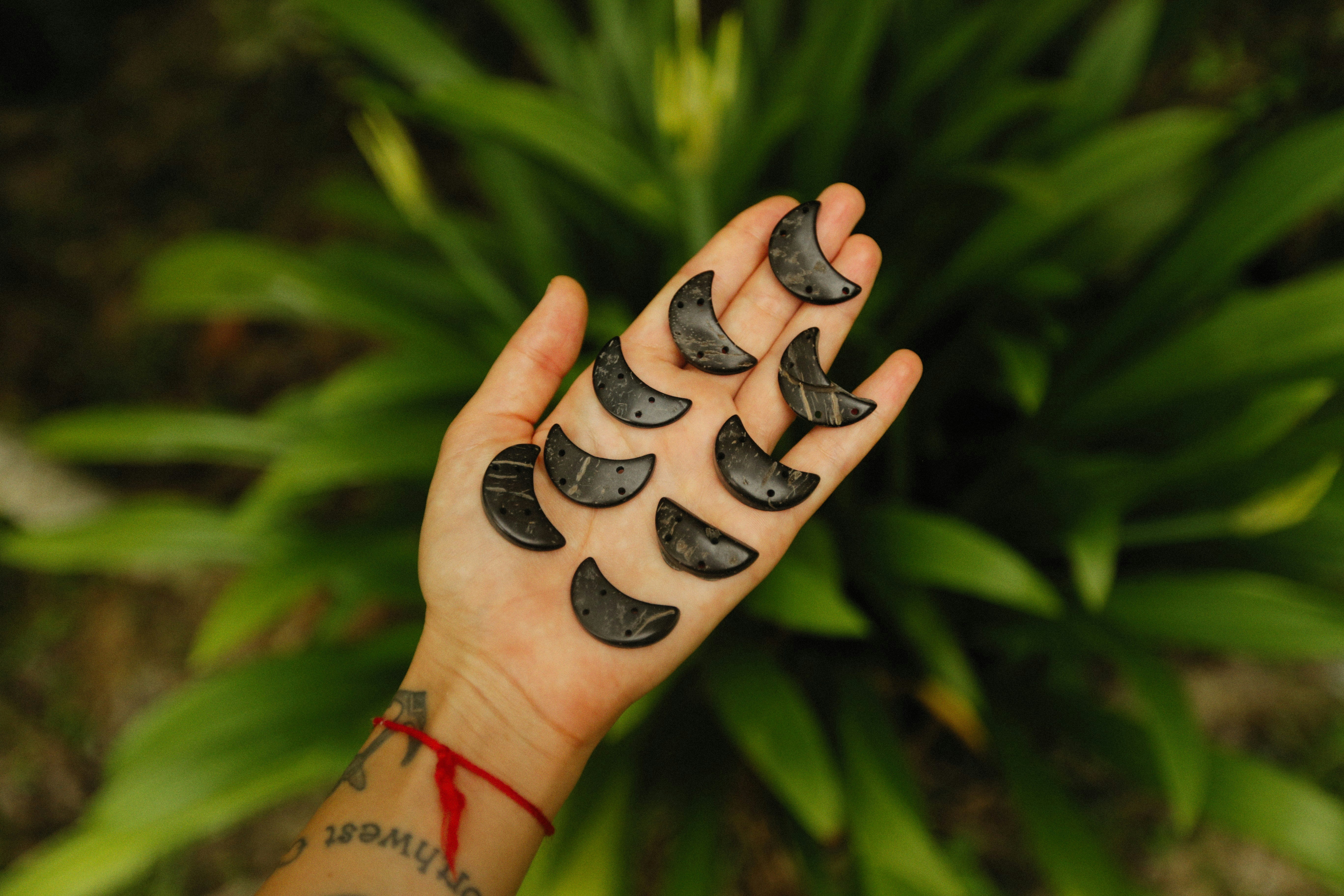 a person's hand with a bunch of black nails on it