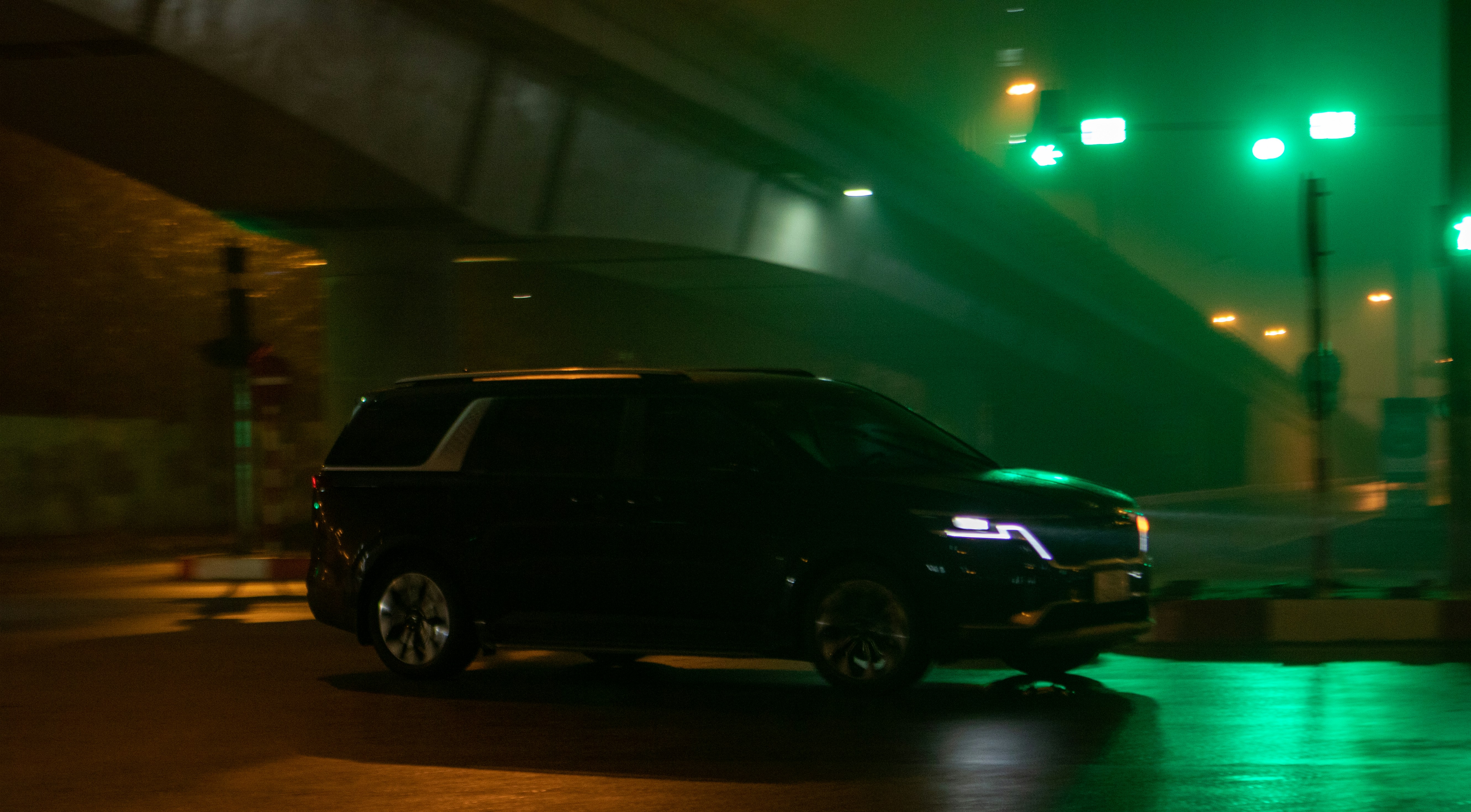 A black suv driving down a street at night photo – Free Automobile ...