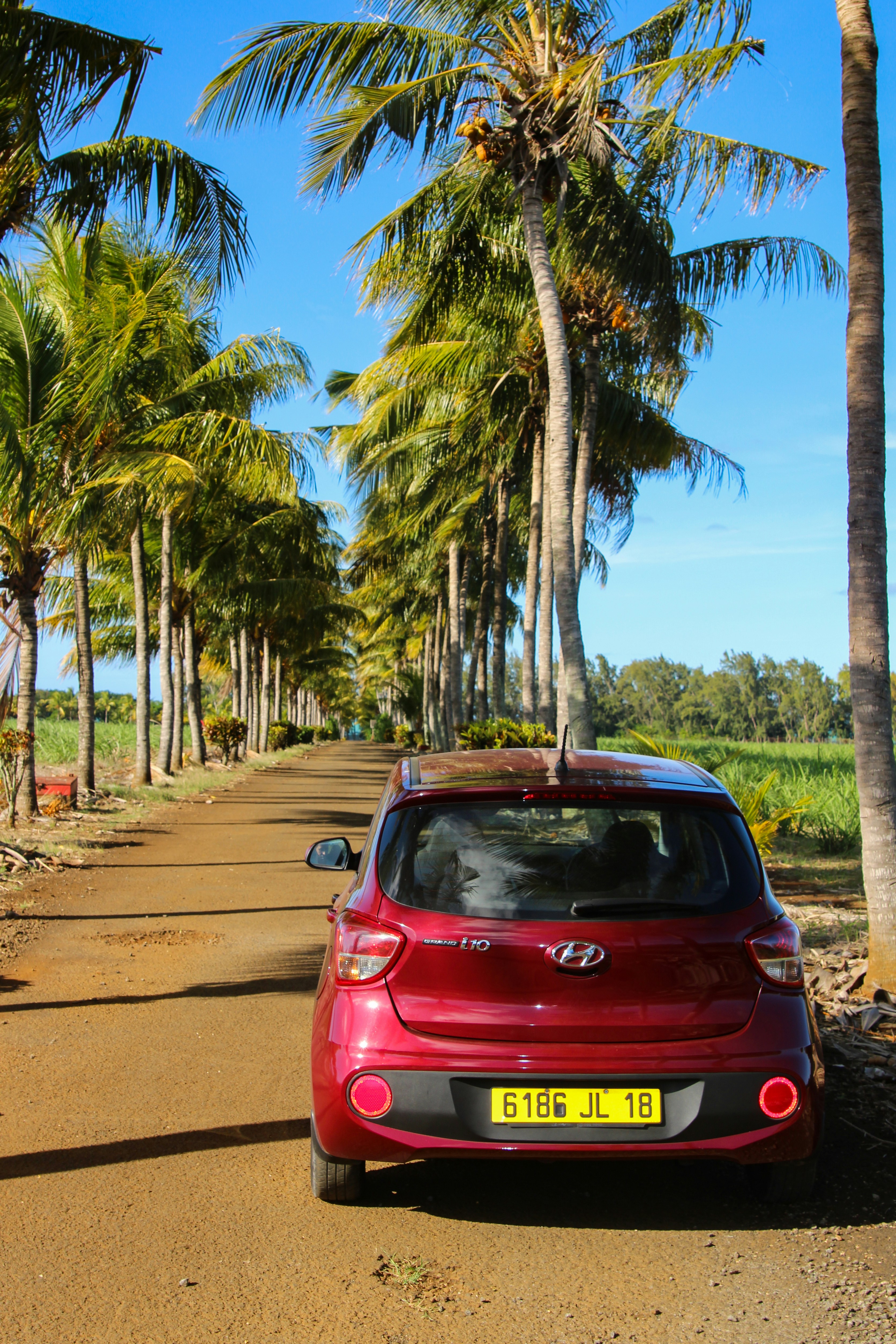 A red car parked on the side of a dirt road photo – Free Mauritius ...