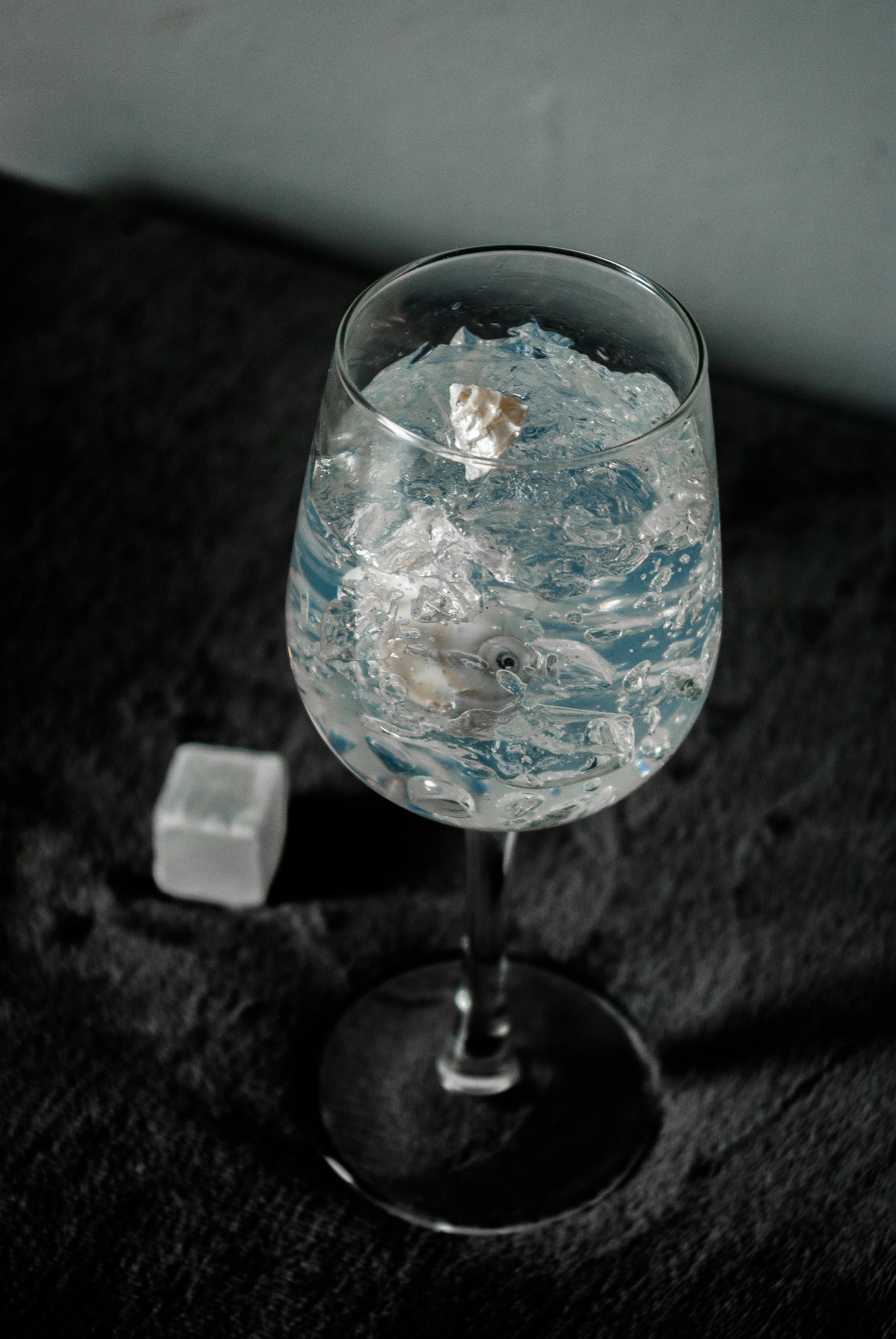 Cobalt Reflections: Ice and Water in a Midnight Wine Glass