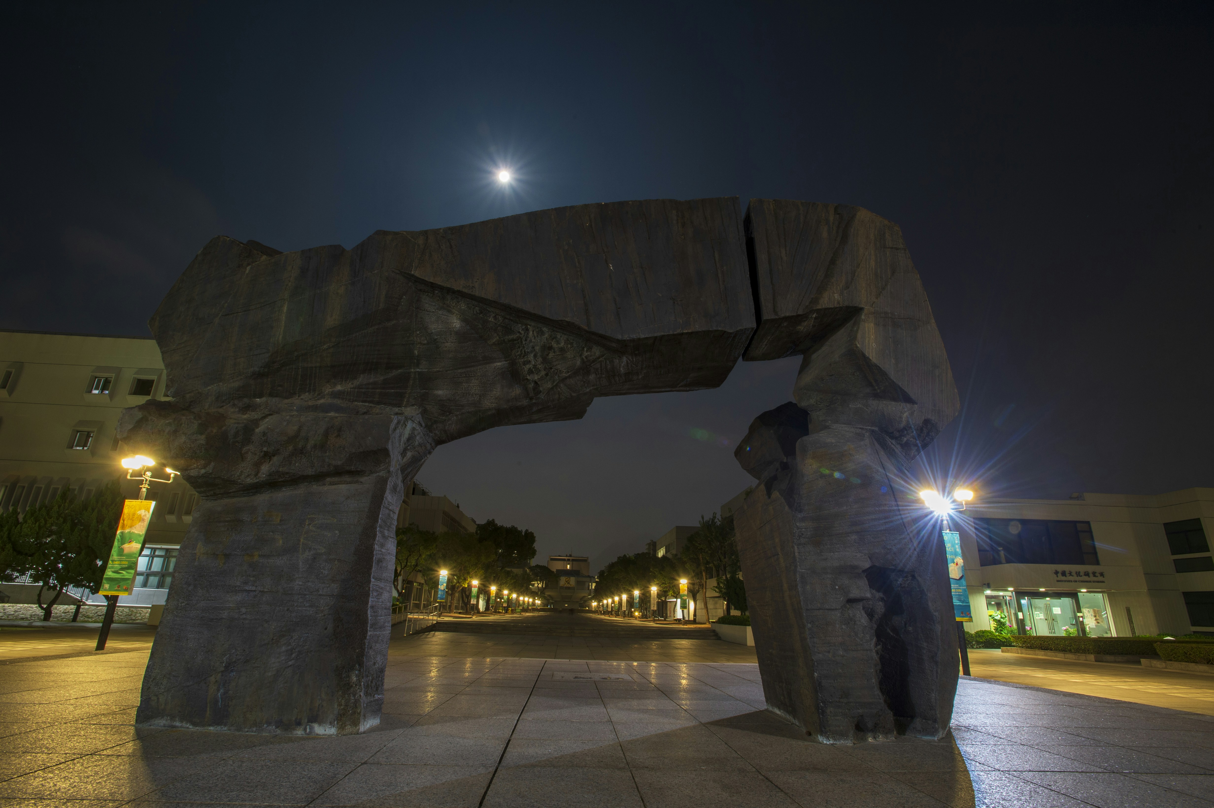 Moonlit Gateway: Granite Arch Framing the Quiet City Night