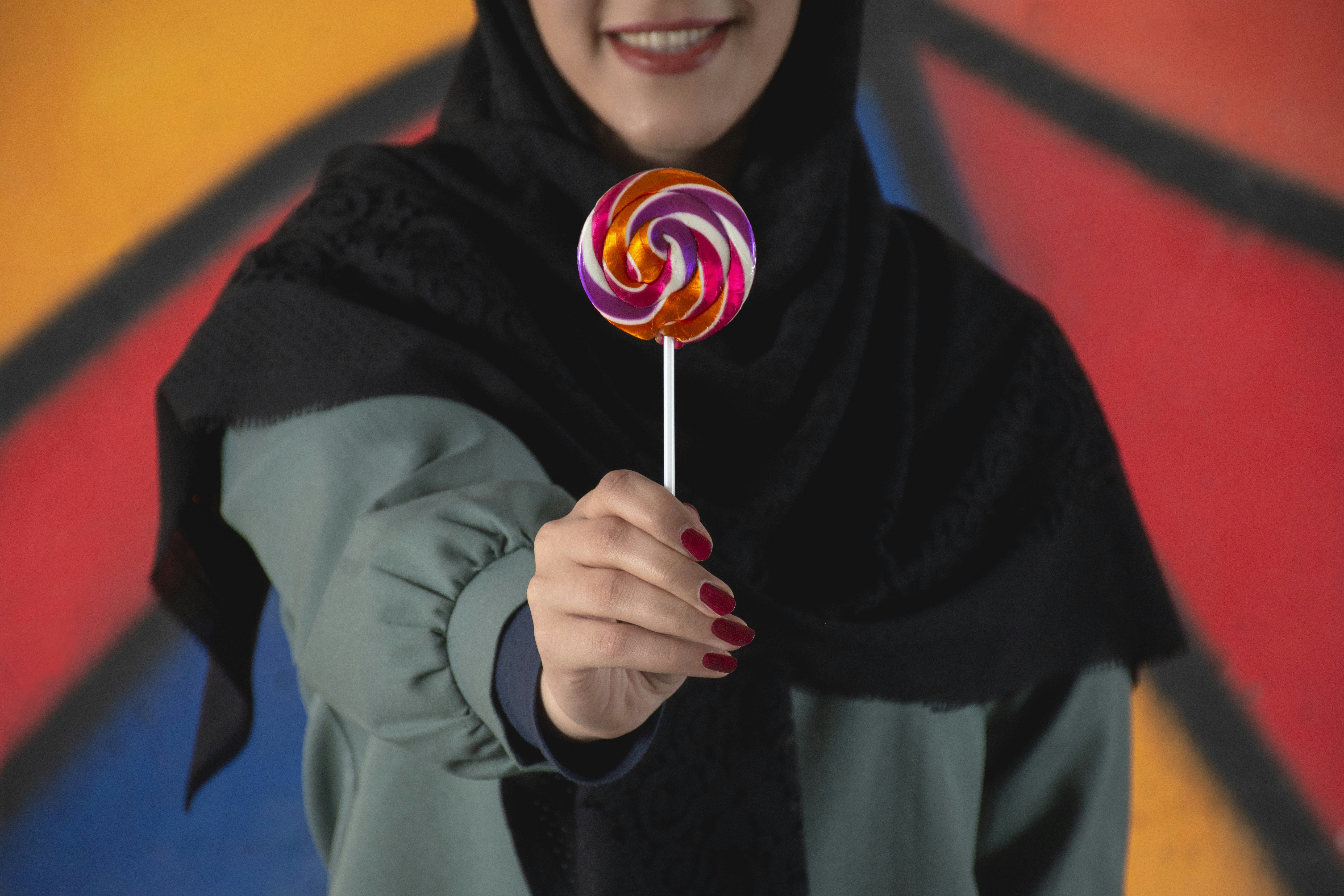 Front-and-Center Swirl: Lollipop Portrait Against a Vivid Graffiti Backdrop