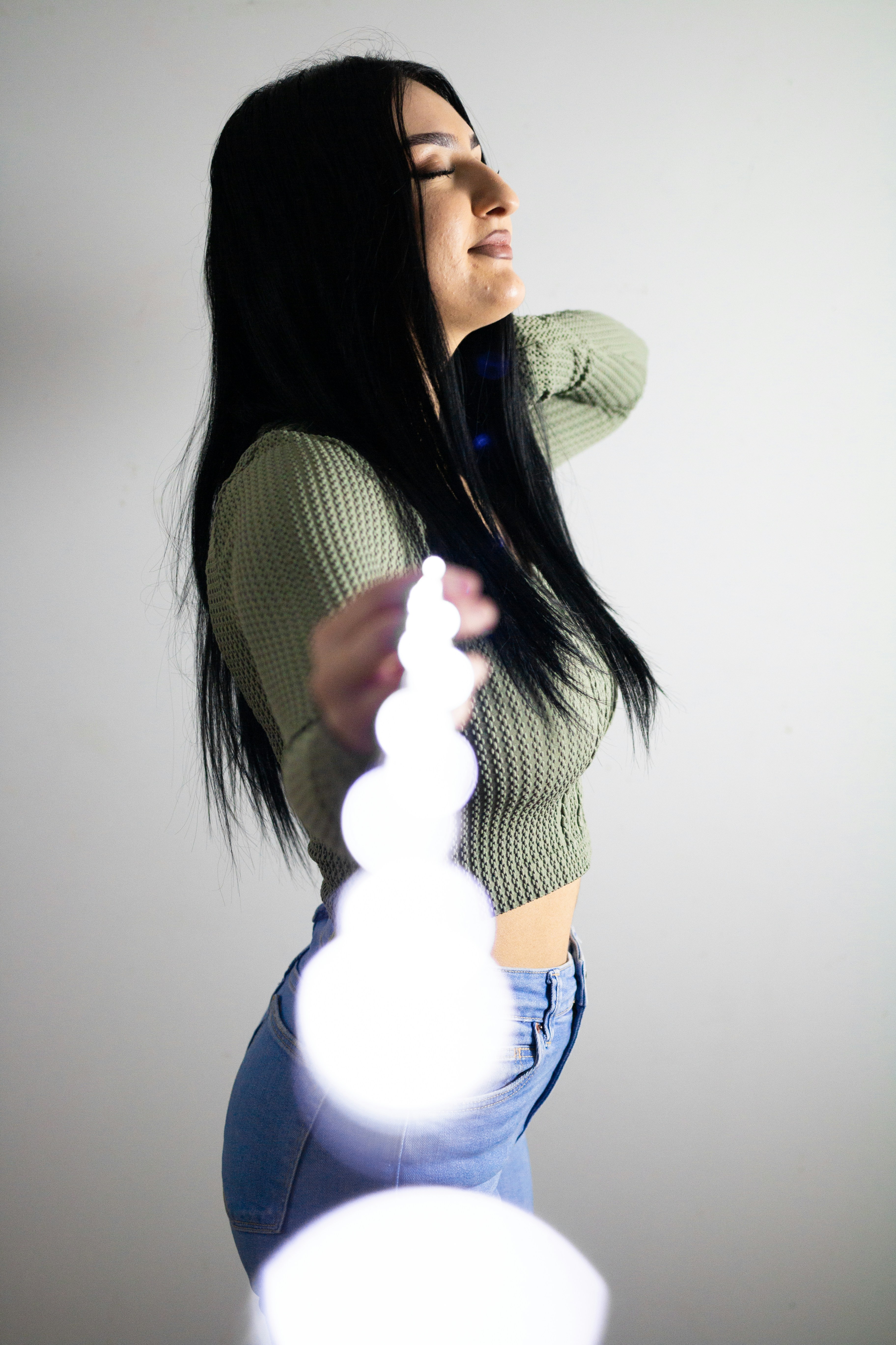 a woman with long black hair holding a white object