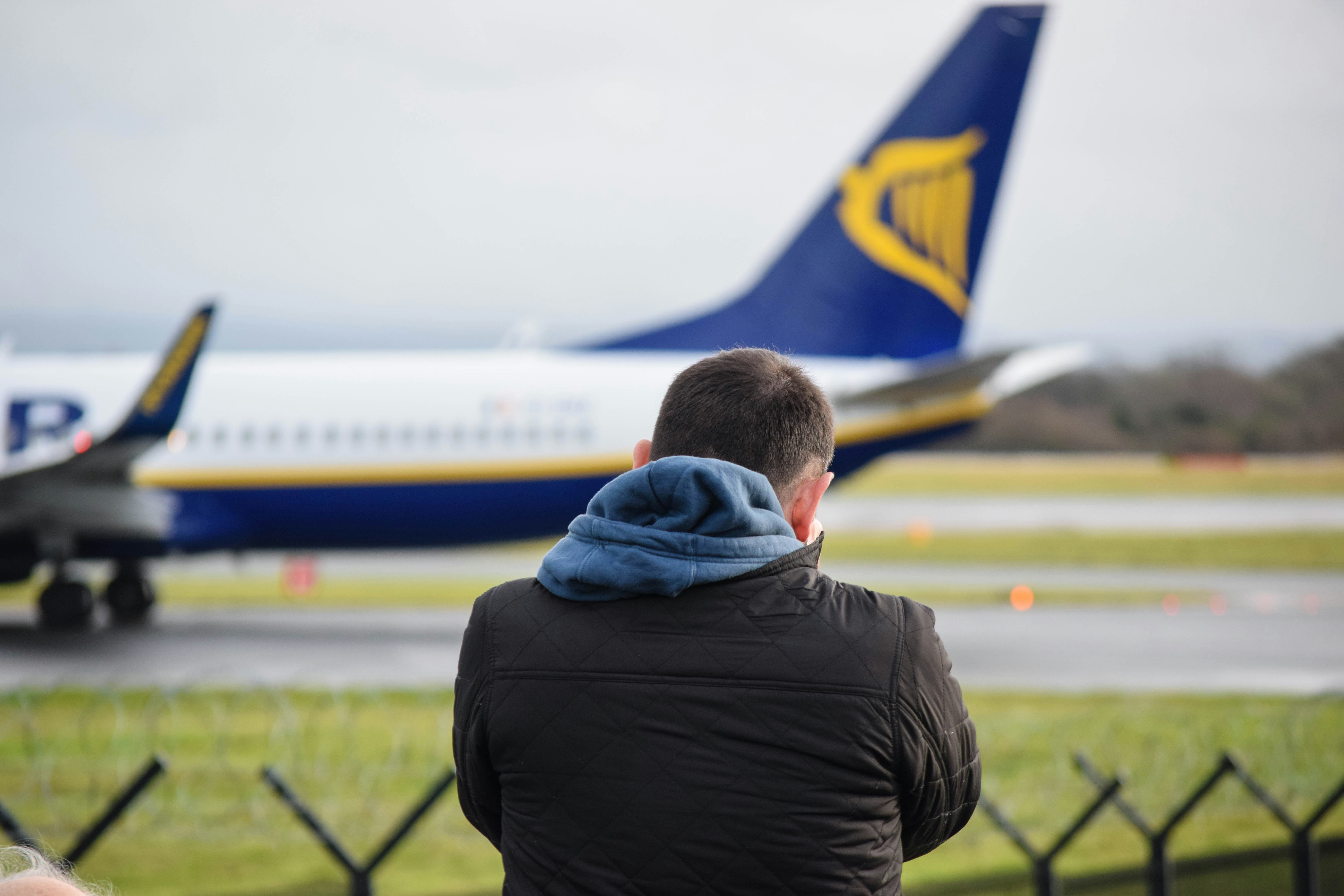 A man looking at a plane on the runway photo – Free Human Image on Unsplash