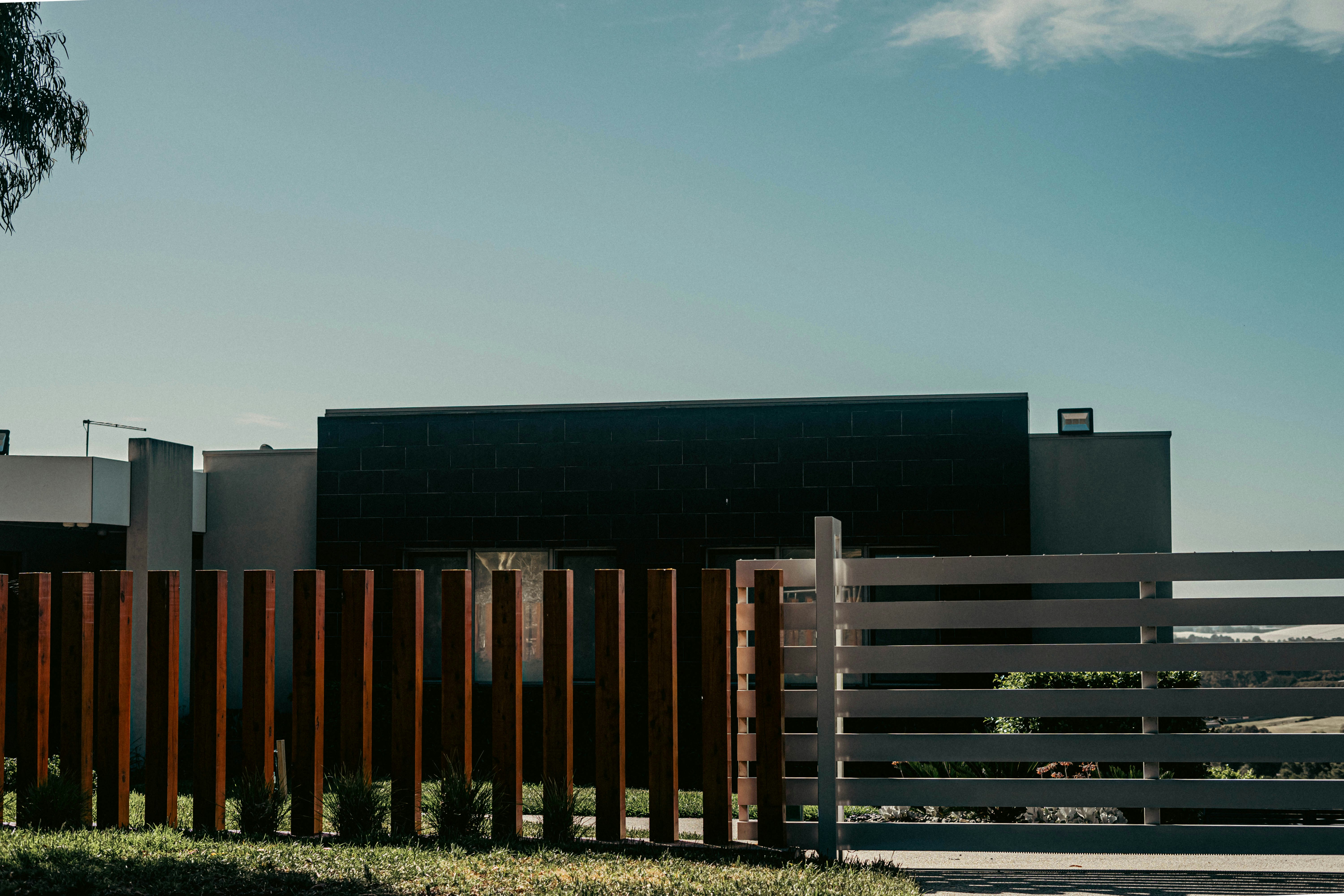 A building with a large wooden fence in front of it photo – Free Plant ...