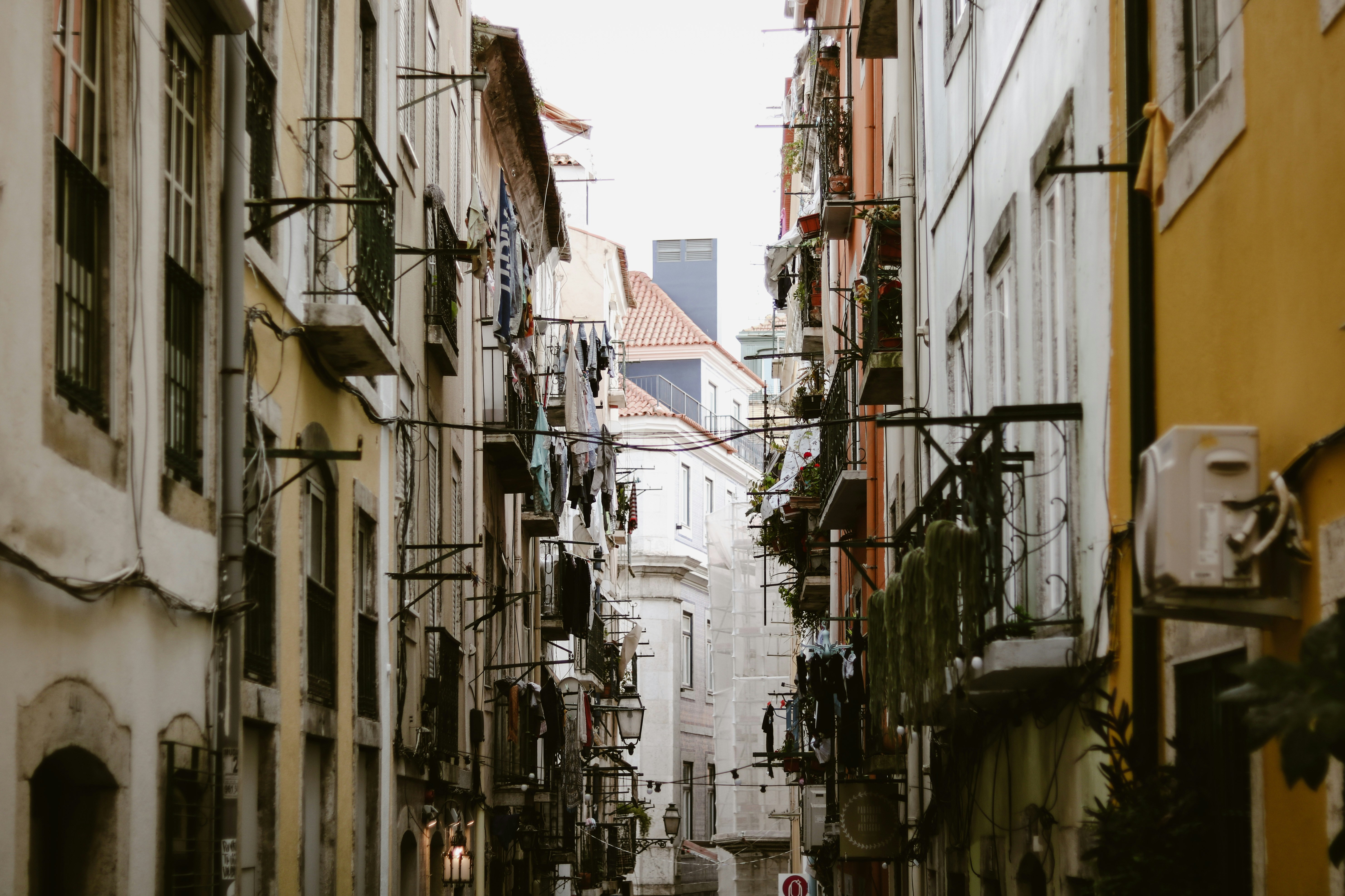A narrow city street lined with tall buildings photo – Free Lissabon ...