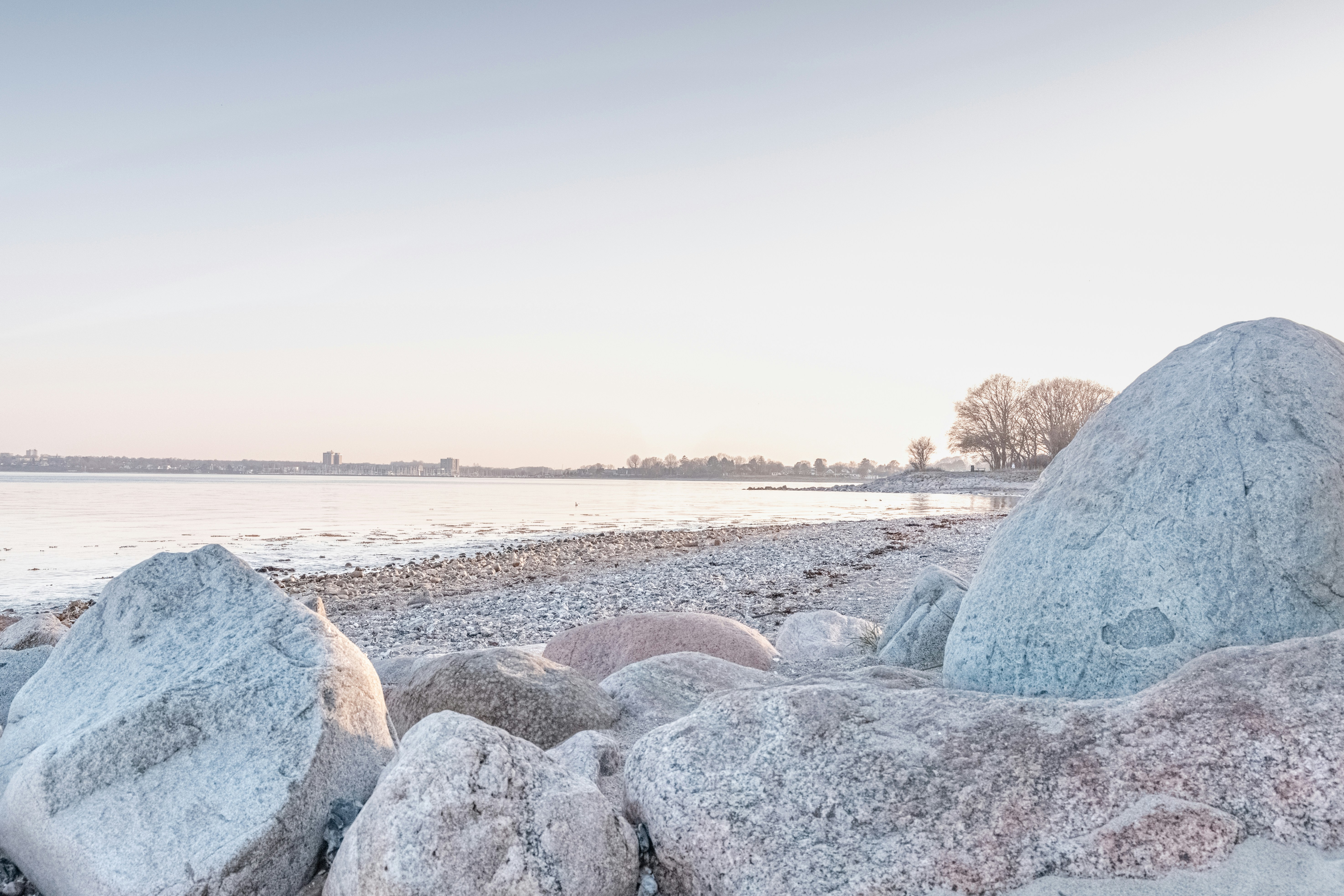 Pebble Giants at Quiet Seashore: Weathered boulders guard a pale horizon