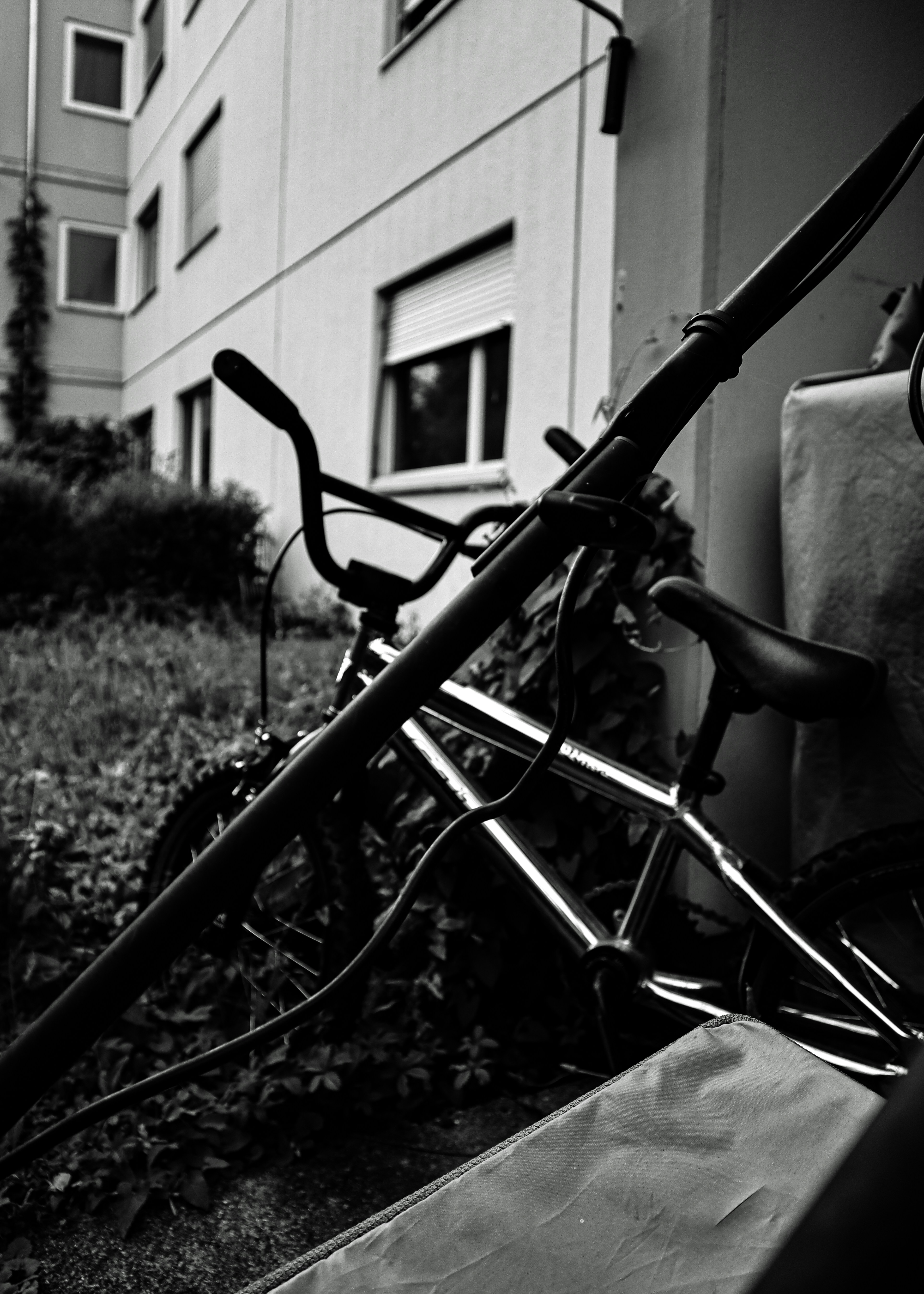 A black and white photo of a bicycle leaning against a building photo ...