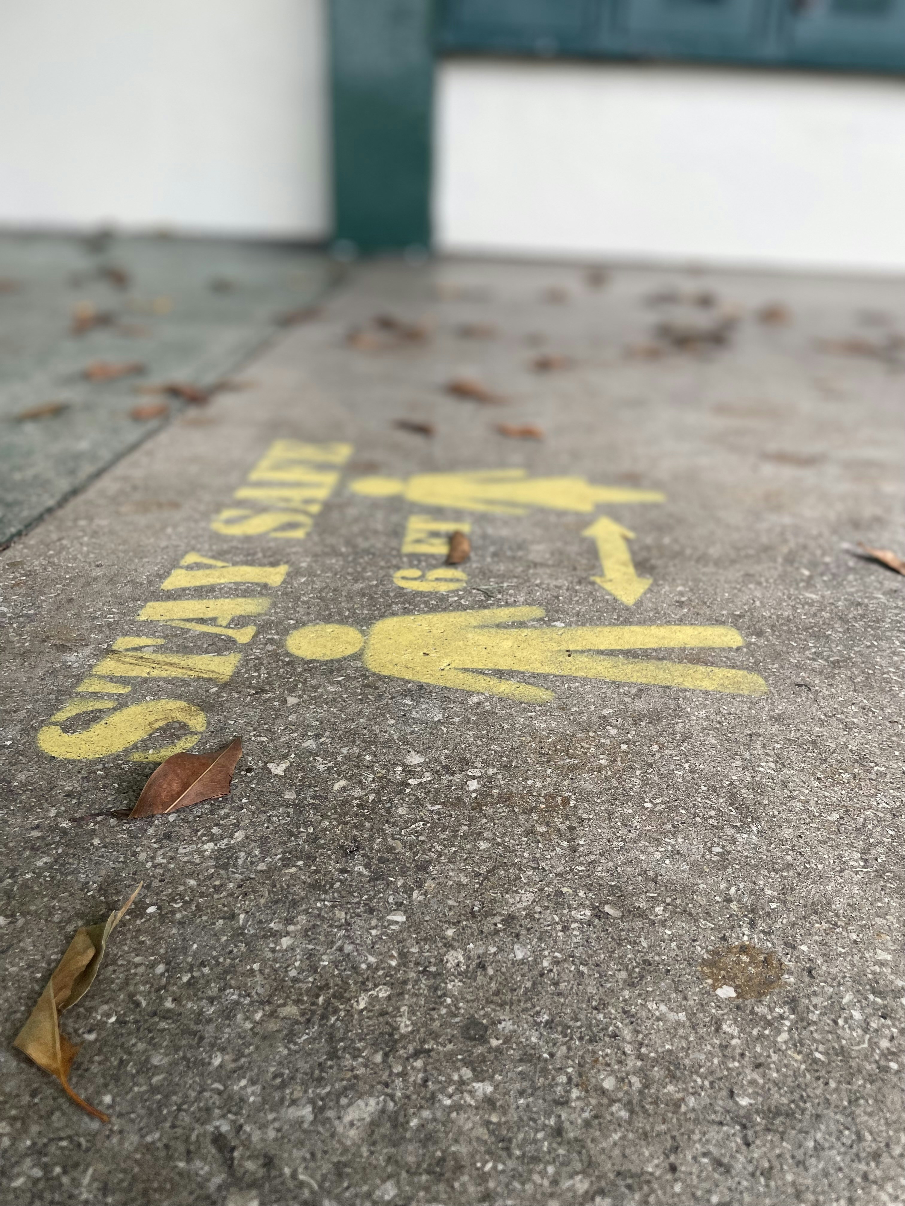 Ground-Level Guide: Yellow Pedestrian Markers on a Quiet Sidewalk