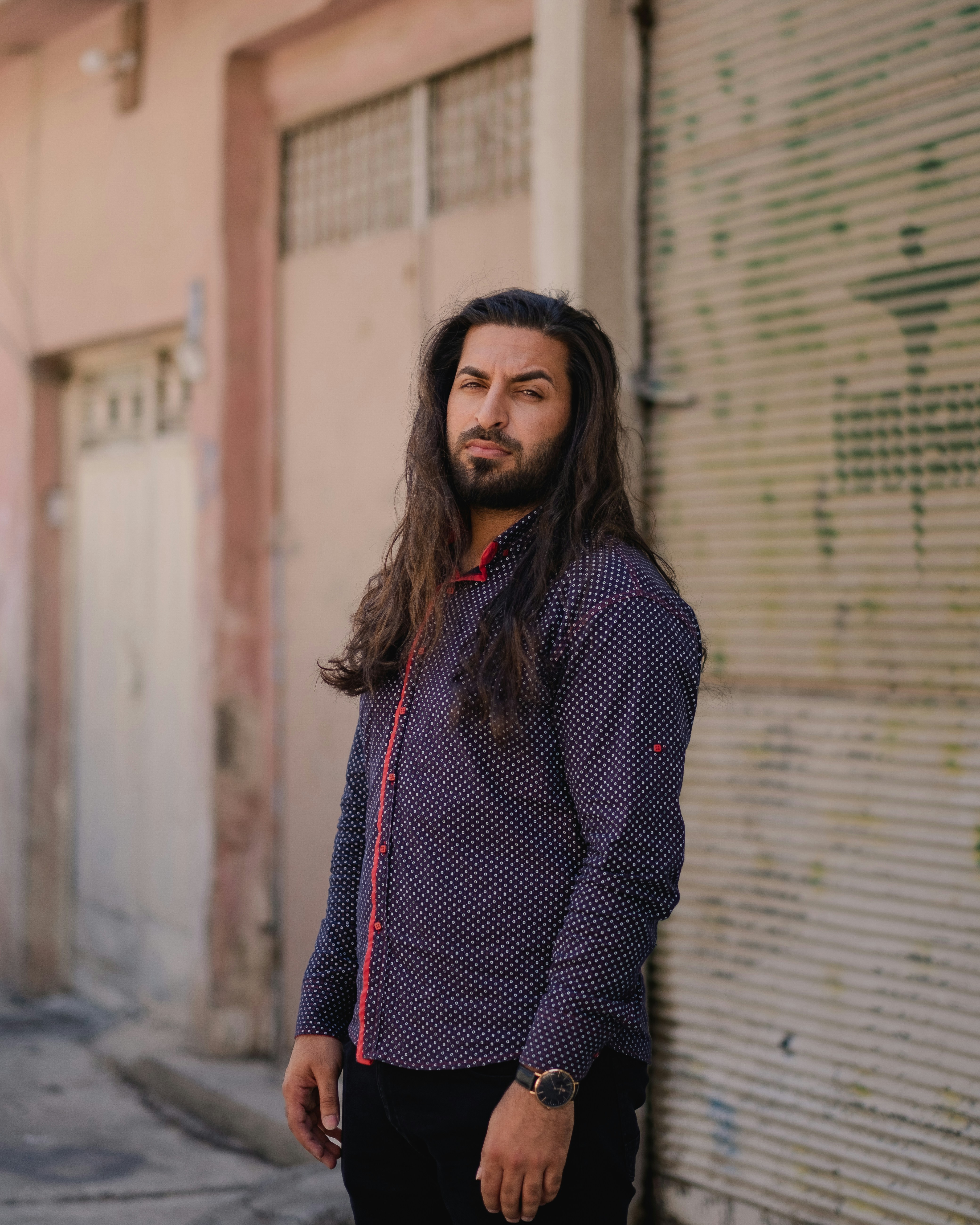 A man with long hair standing in front of a building photo – Free Iraq ...