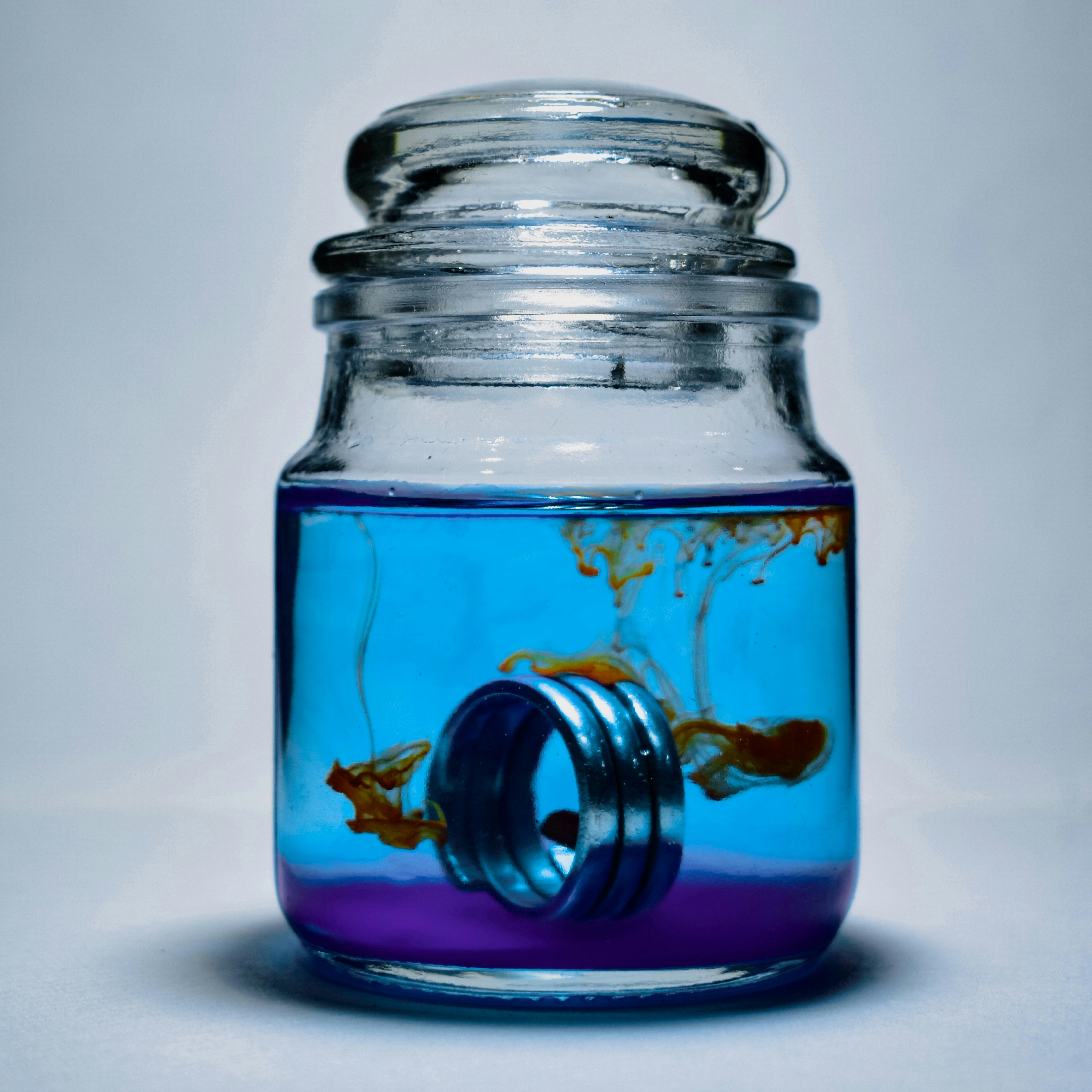 A glass jar filled with blue liquid and goldfish photo – Free Ink in ...