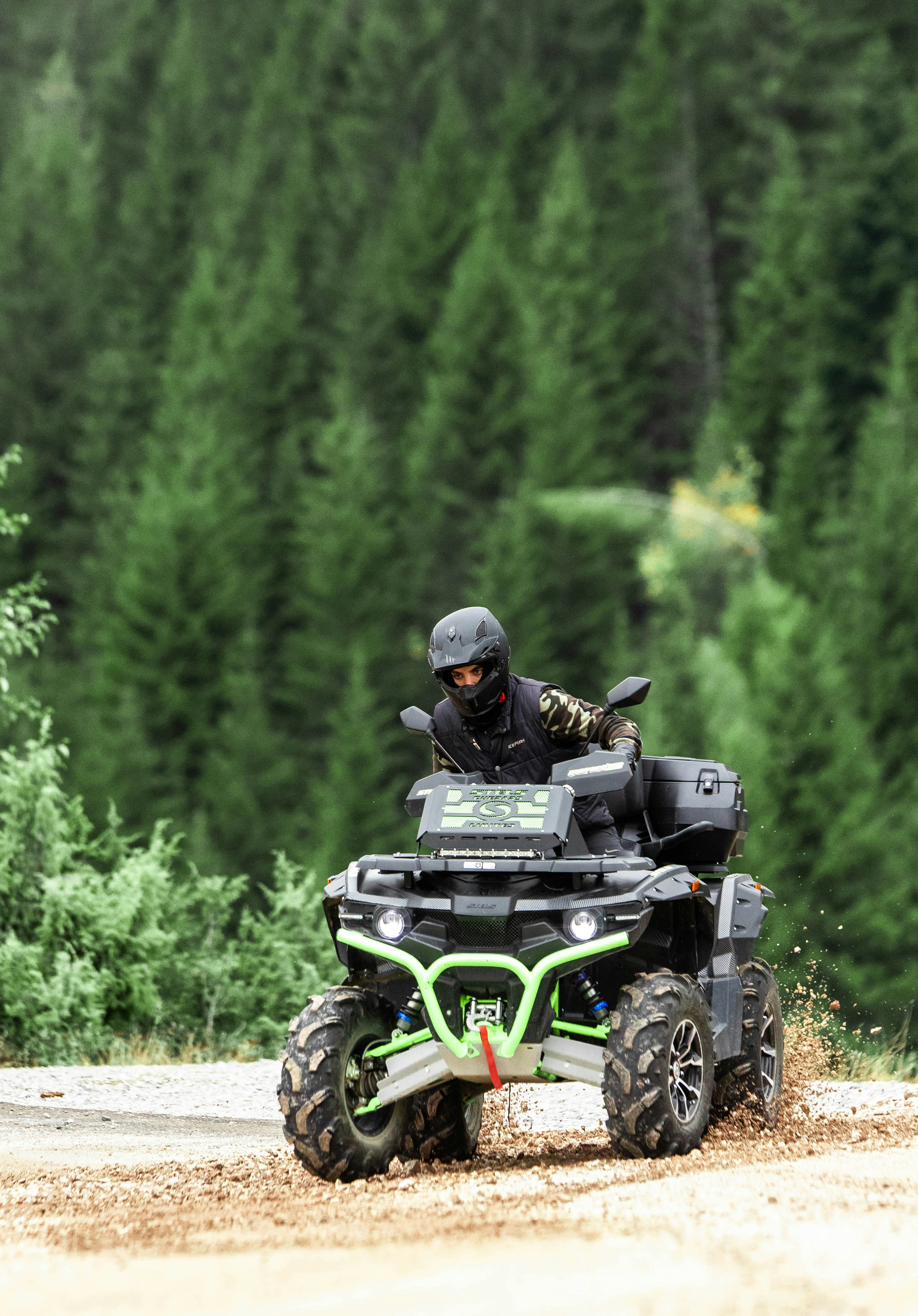 A man riding an atv on a dirt road photo – Free Helmet Image on Unsplash