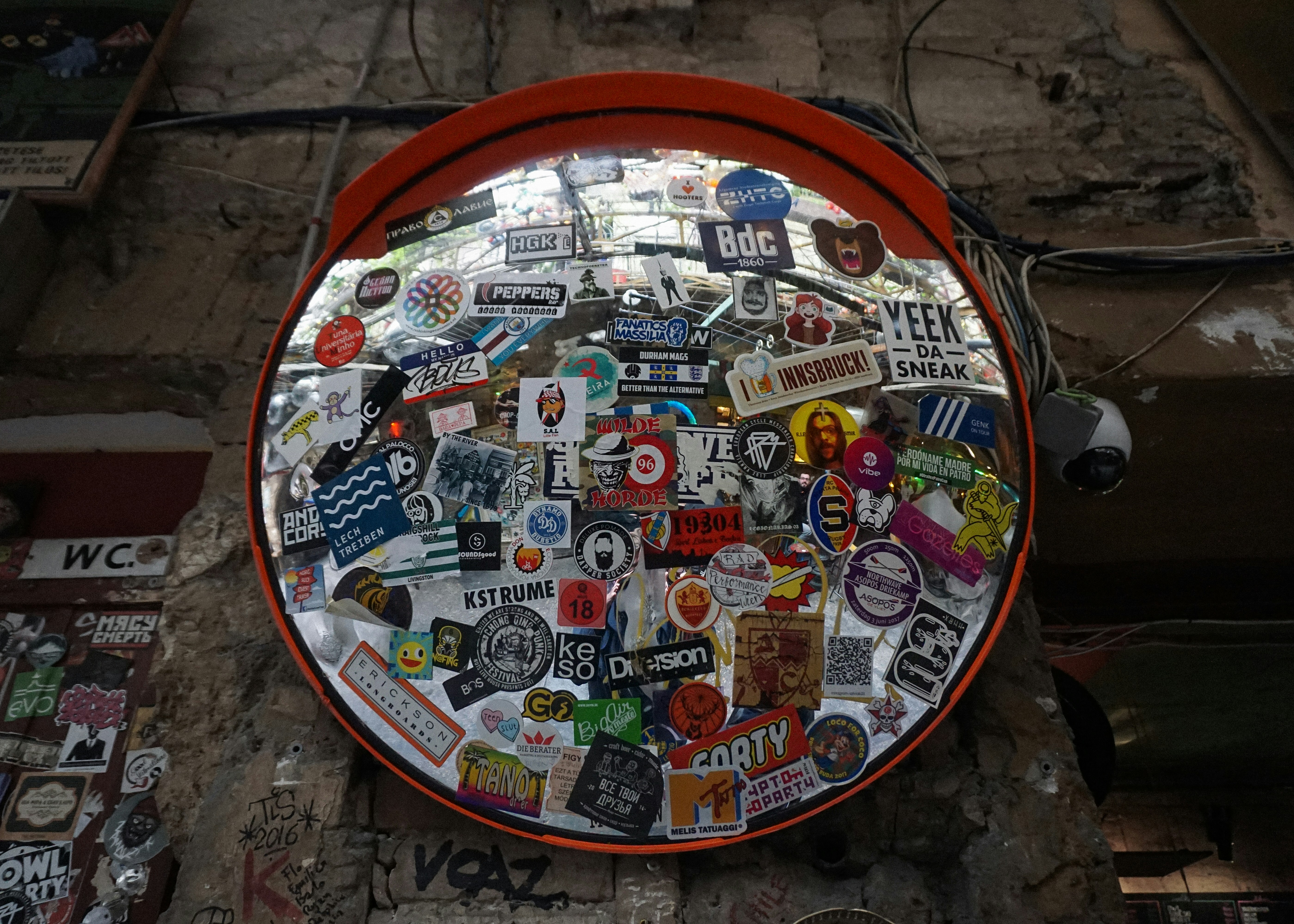 Sticker Nebula on a Red Rim: A Circular Canvas of Urban Ephemera