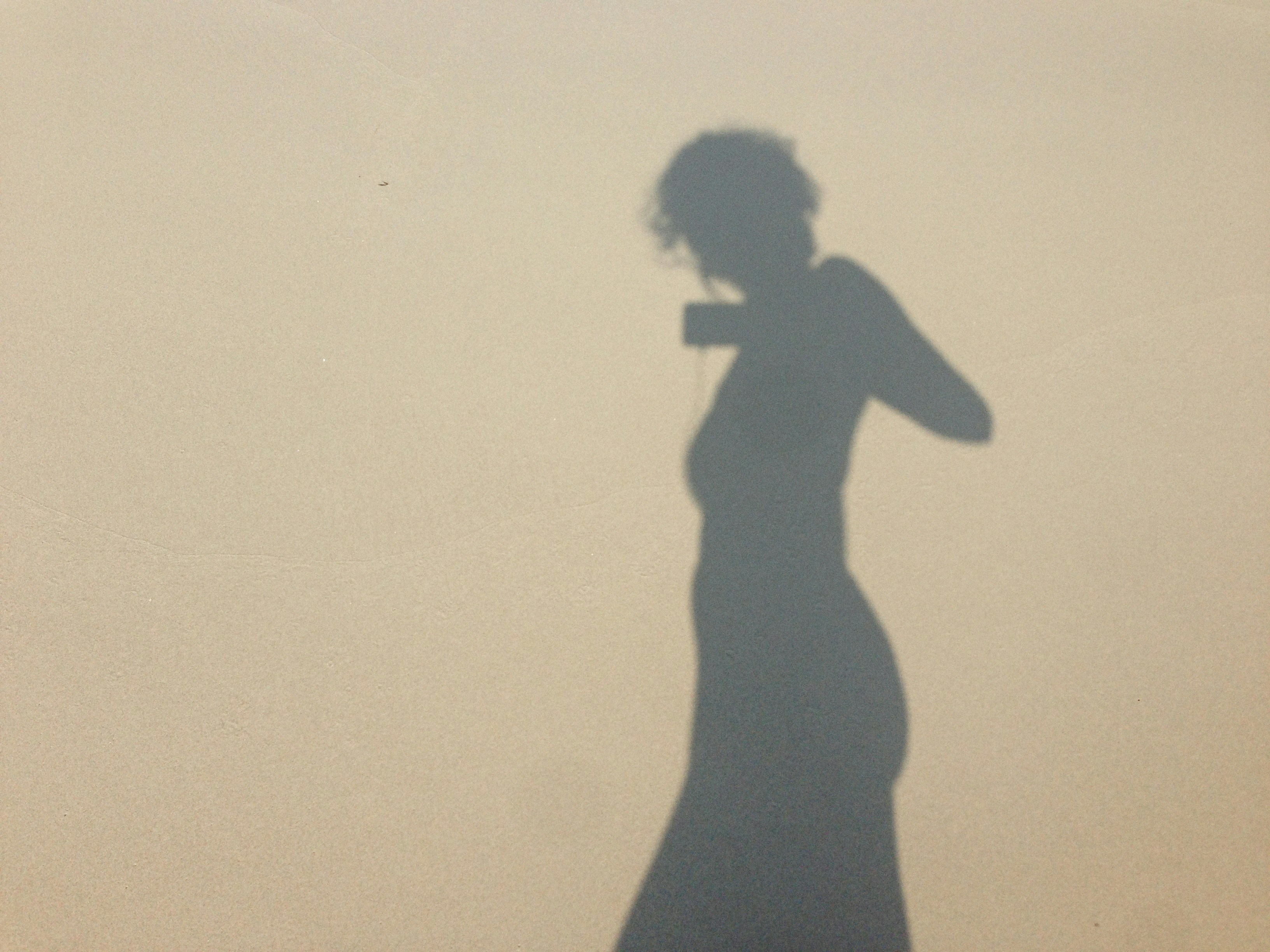 Shadow Portrait on Burnished Sand: A Lone Beach Silhouette in Quiet Light