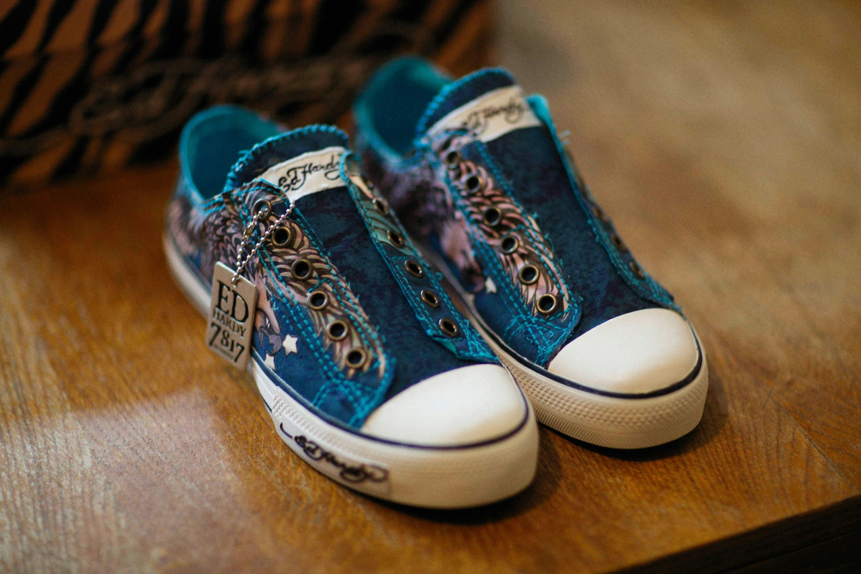 Tagged Blue Canvas Sneakers Rest on a Warm Wooden Floor