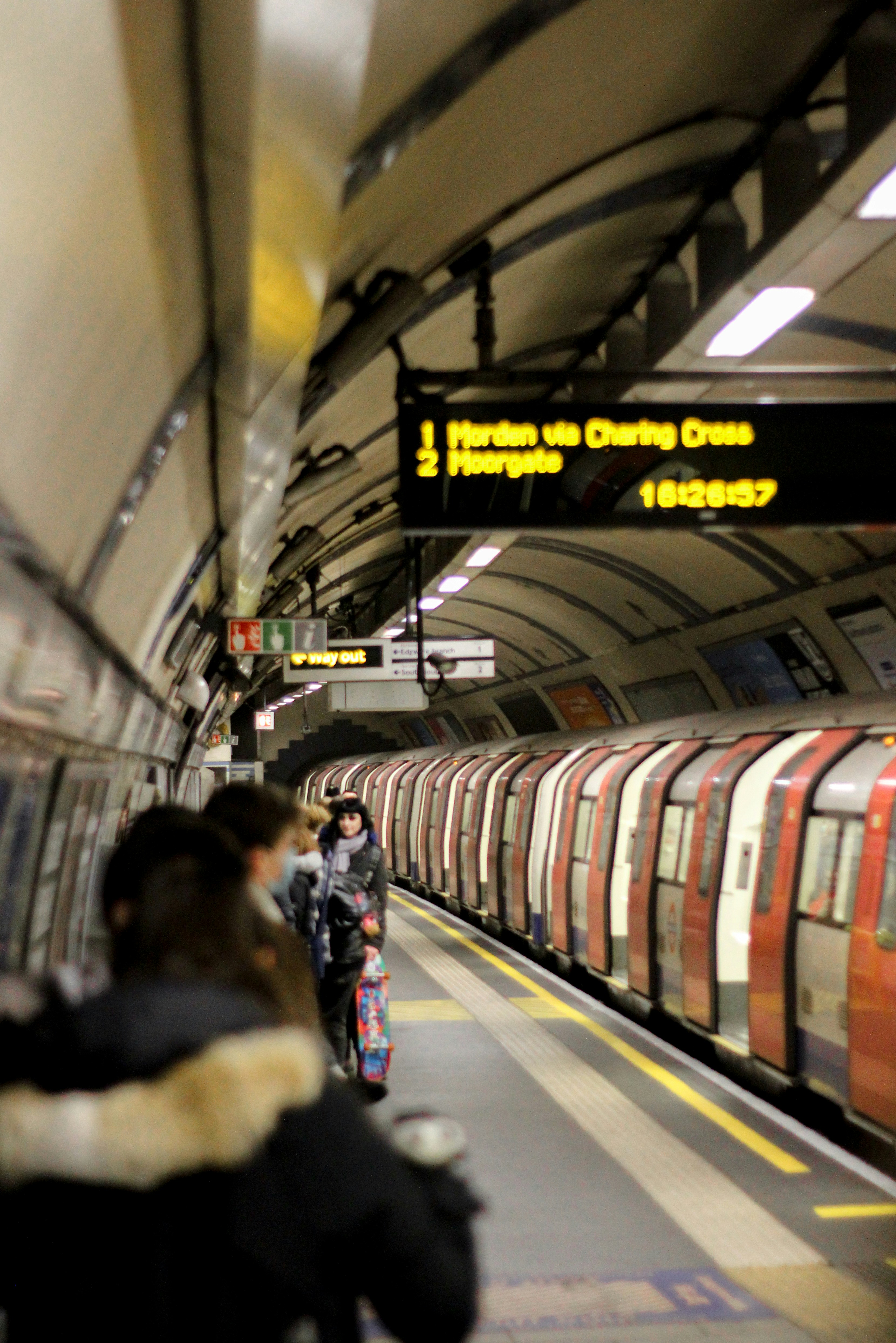 Neon Signover: Quiet Figures on a Curved Underground Platform