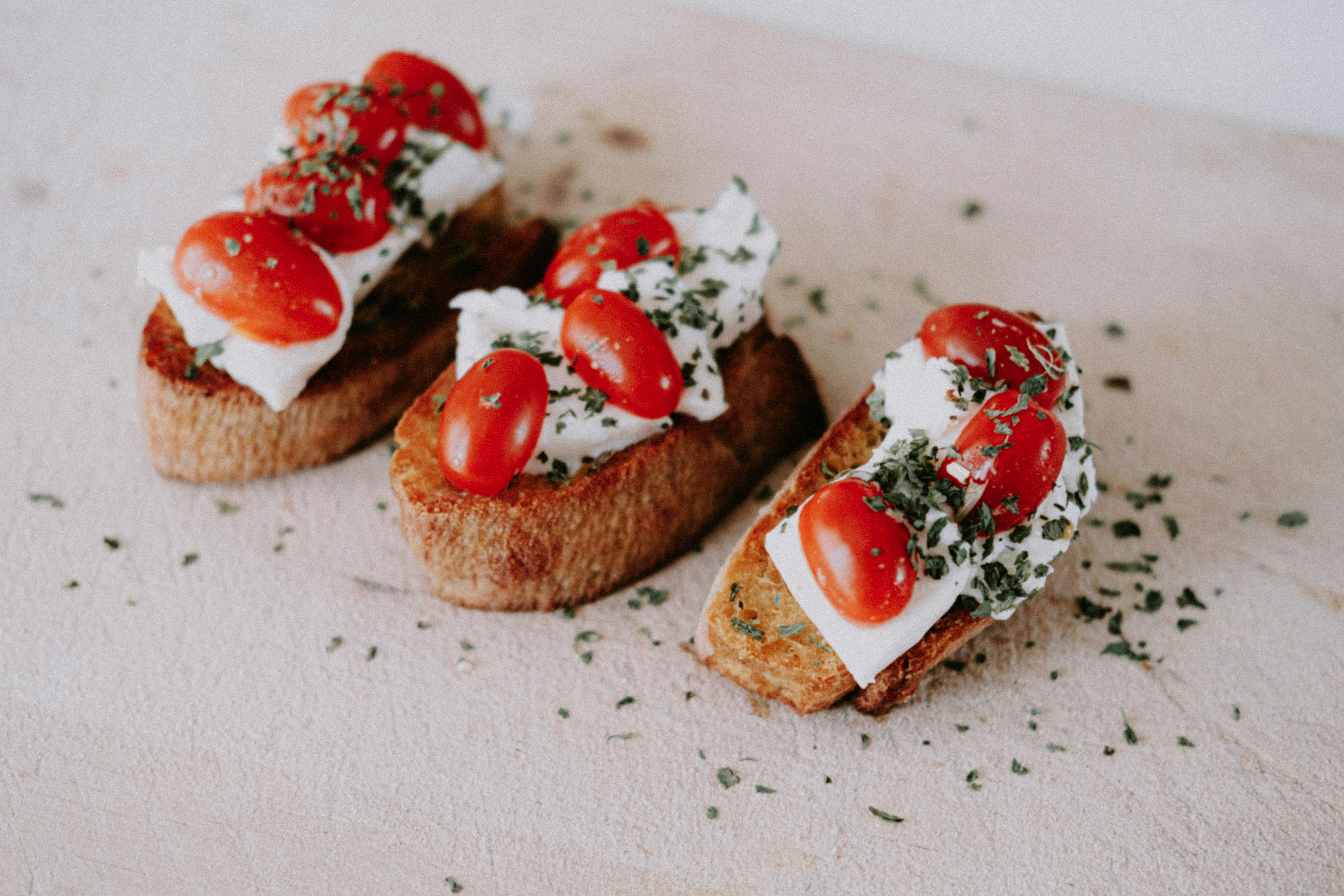 Trois petits morceaux de pain garnis de tomates et de crème photo ...