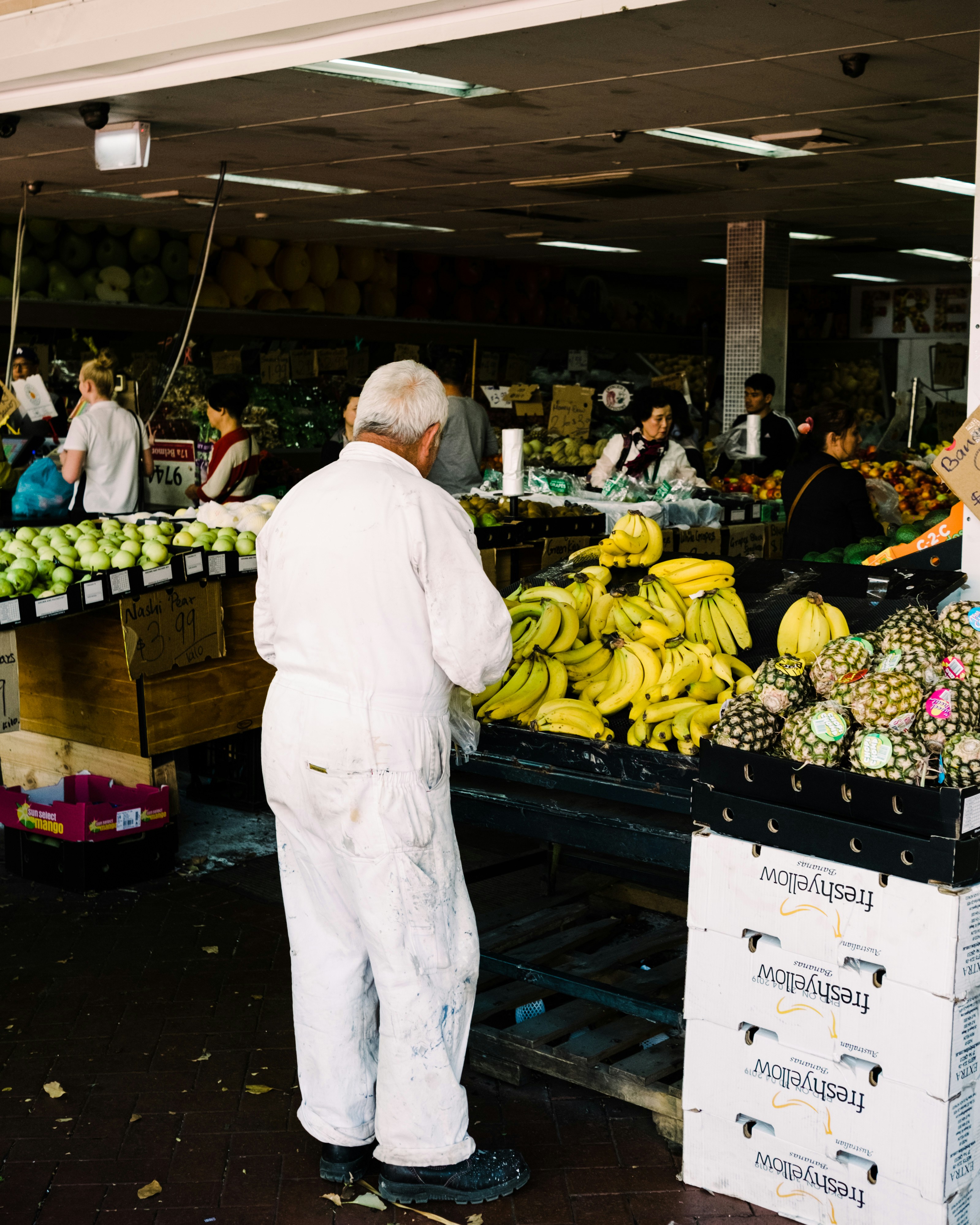 a man standing in front of a fruit stand
