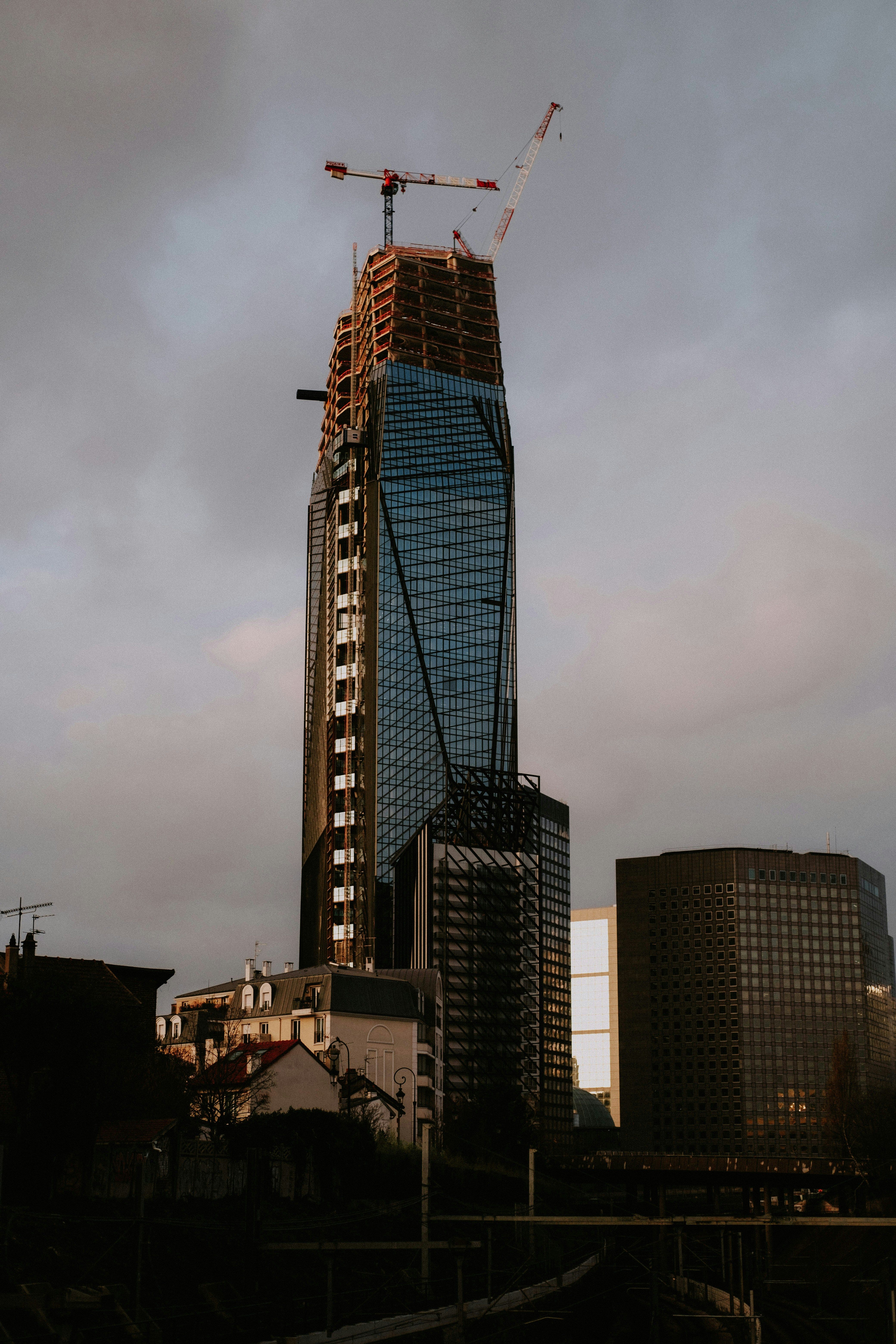 Foto Un edificio alto con una grúa encima – Imagen París gratis en Unsplash