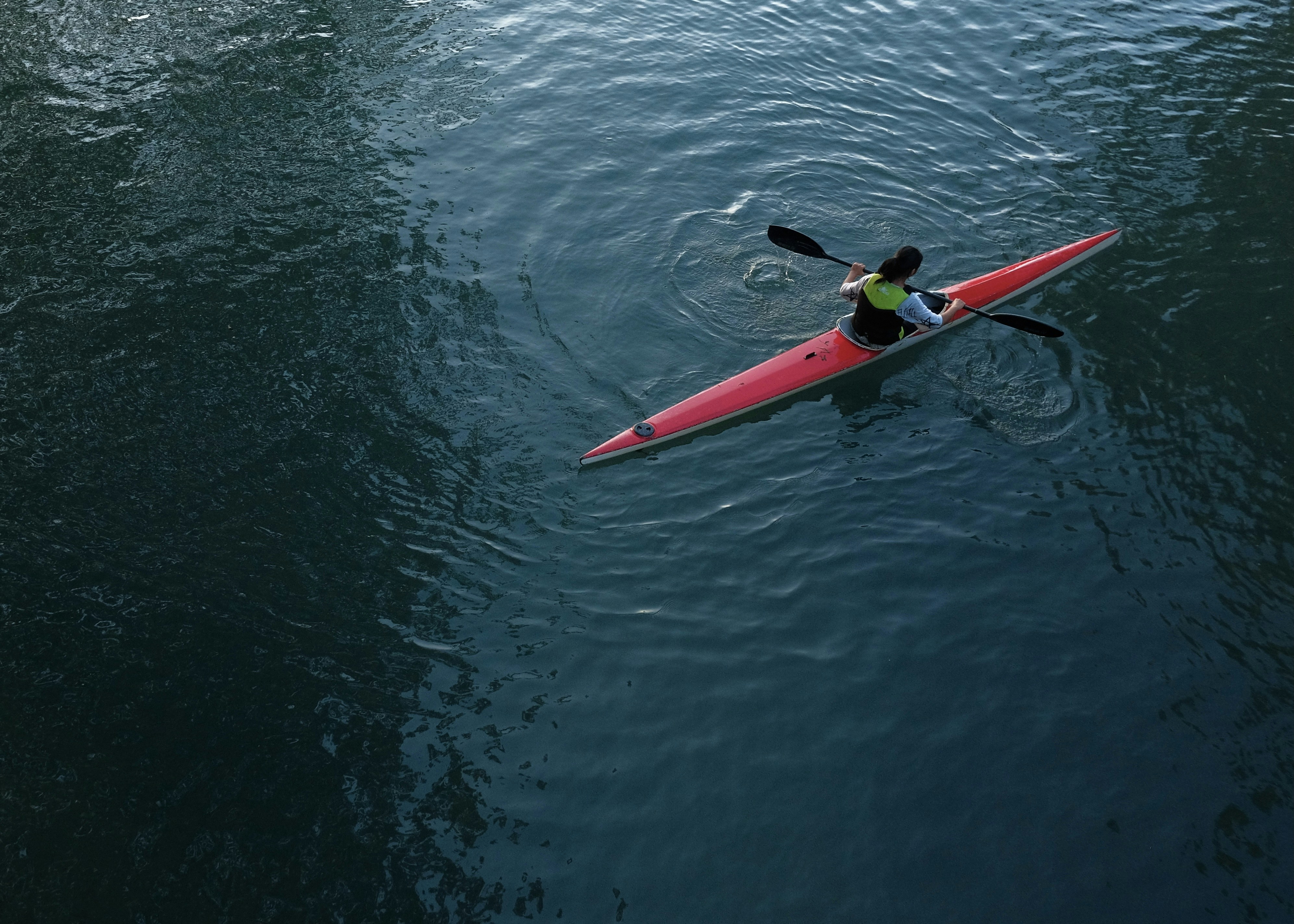A person in a kayak paddling on a body of water photo – Free Grey Image ...