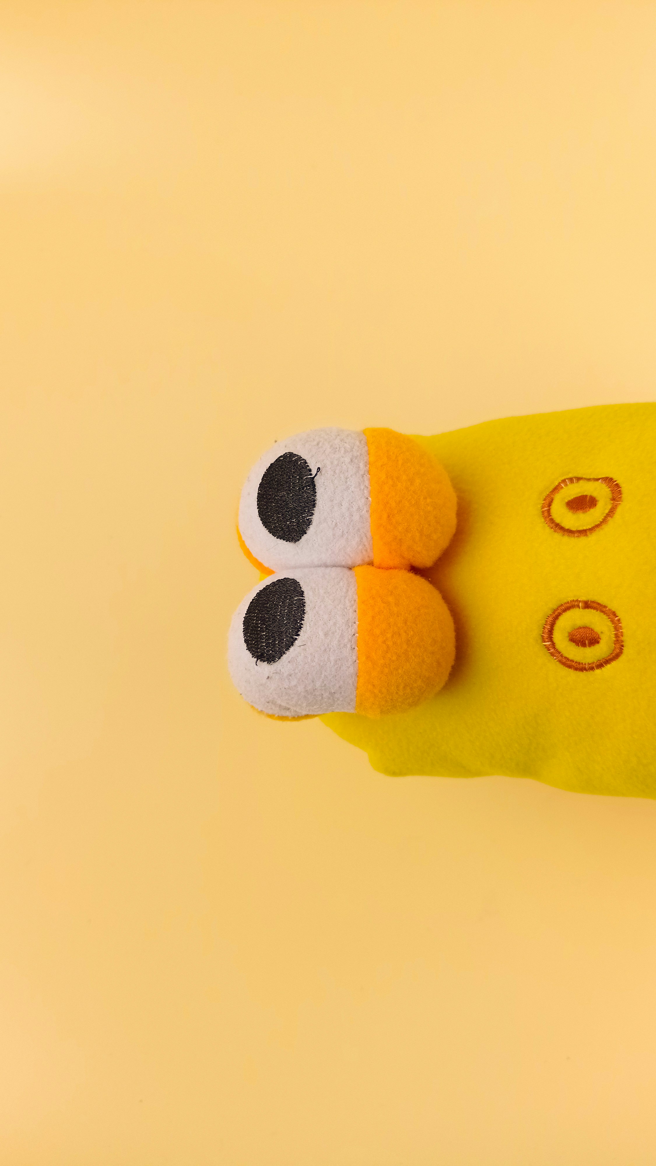 Un animal en peluche jaune avec des yeux et un nez photo – Image ...