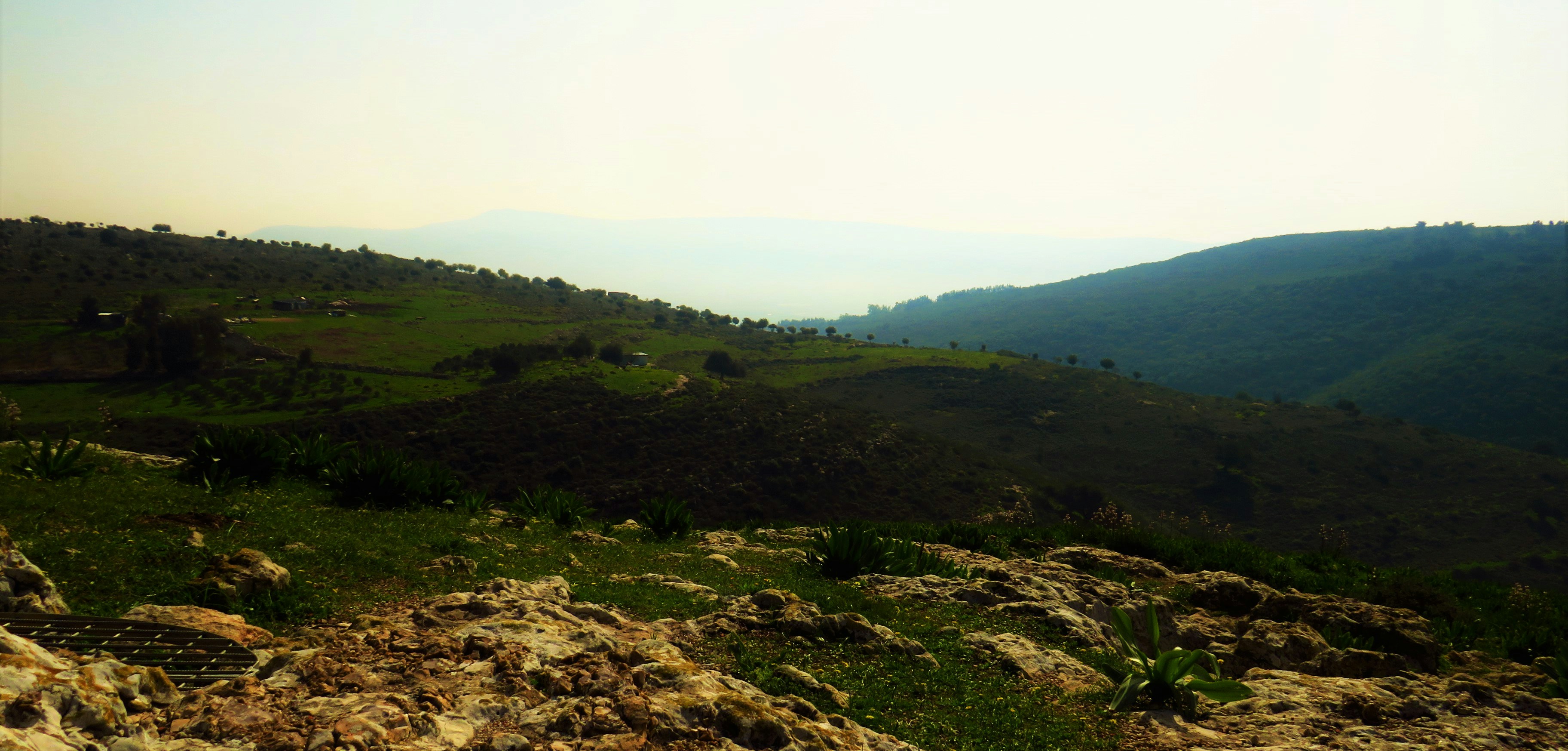 A view of a valley with a few hills in the distance photo – Free ...