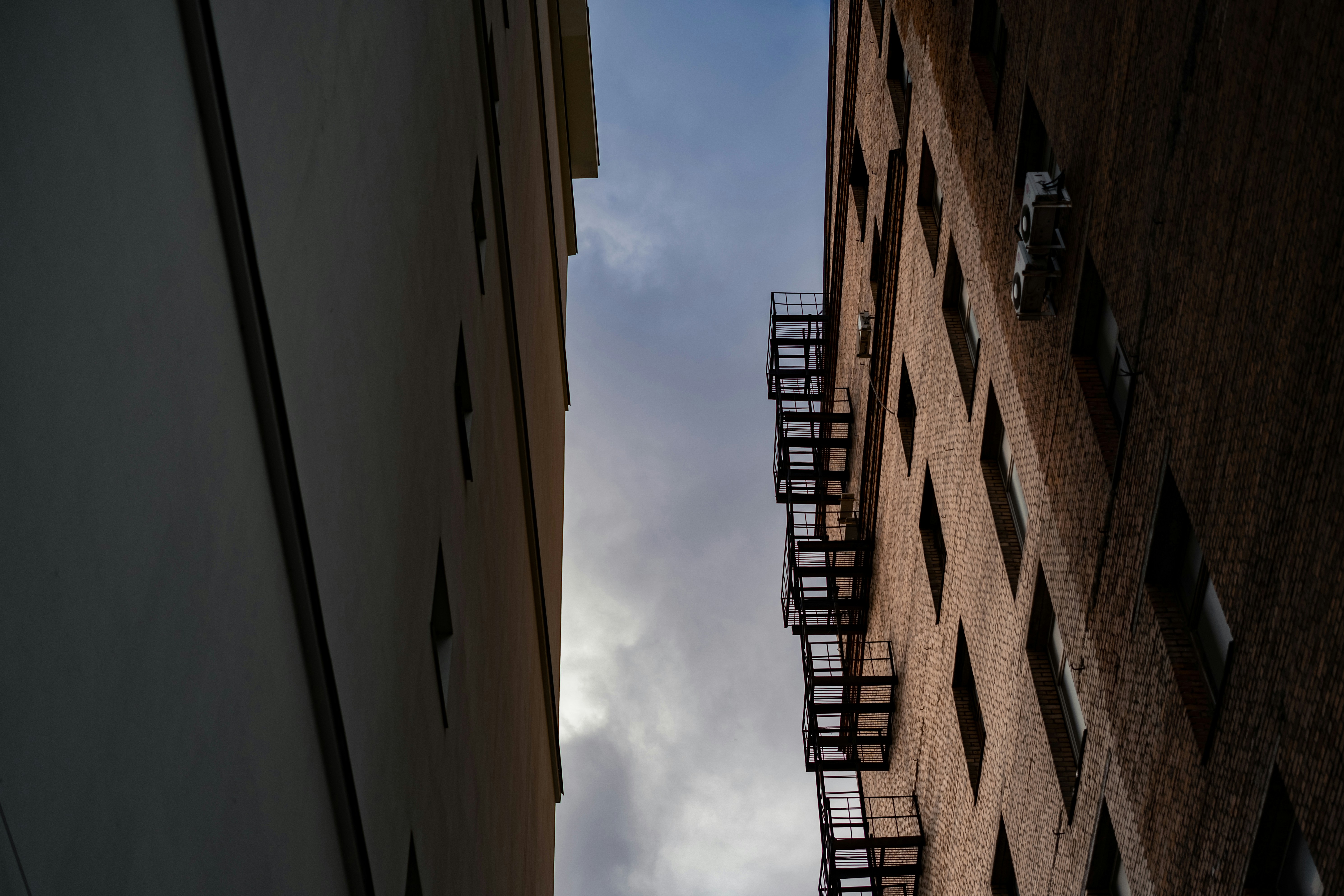 A tall building with a fire escape on the side of it photo – Free ...