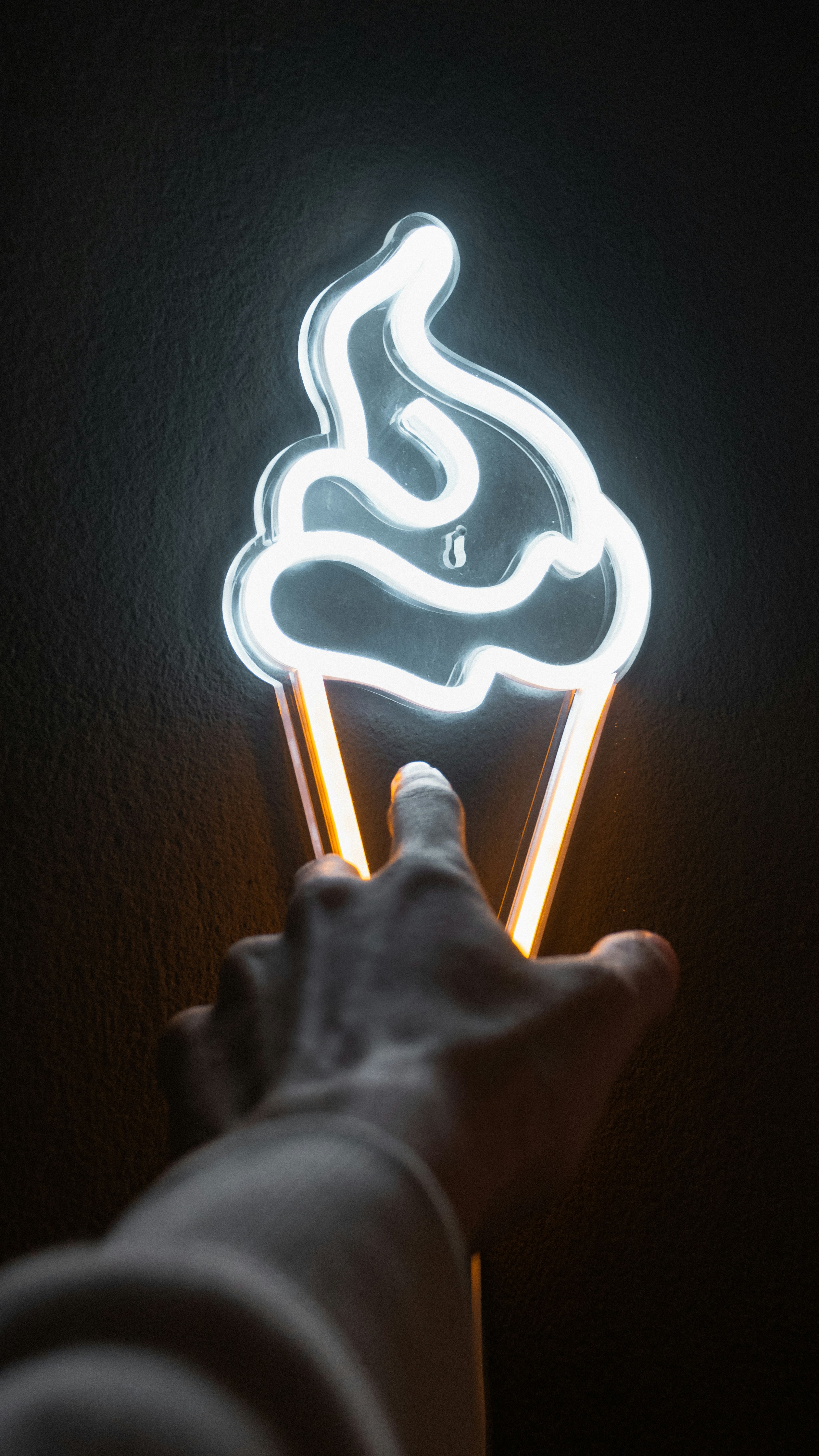 Neon Cone Convergence: A Hand Reaches Toward a Glowing Sign