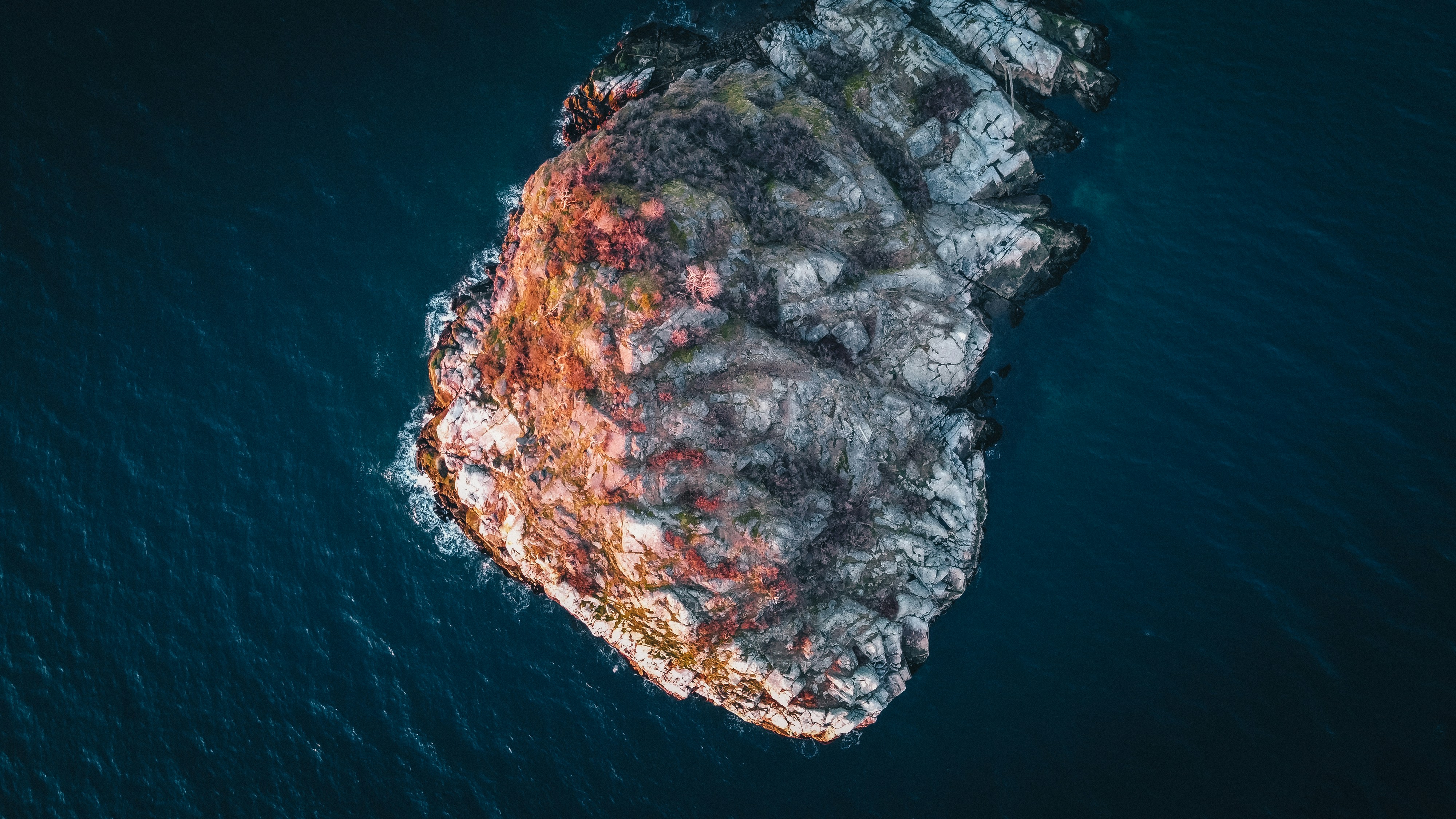 Sunlit Islet in Azure: A Lone Rock from Above
