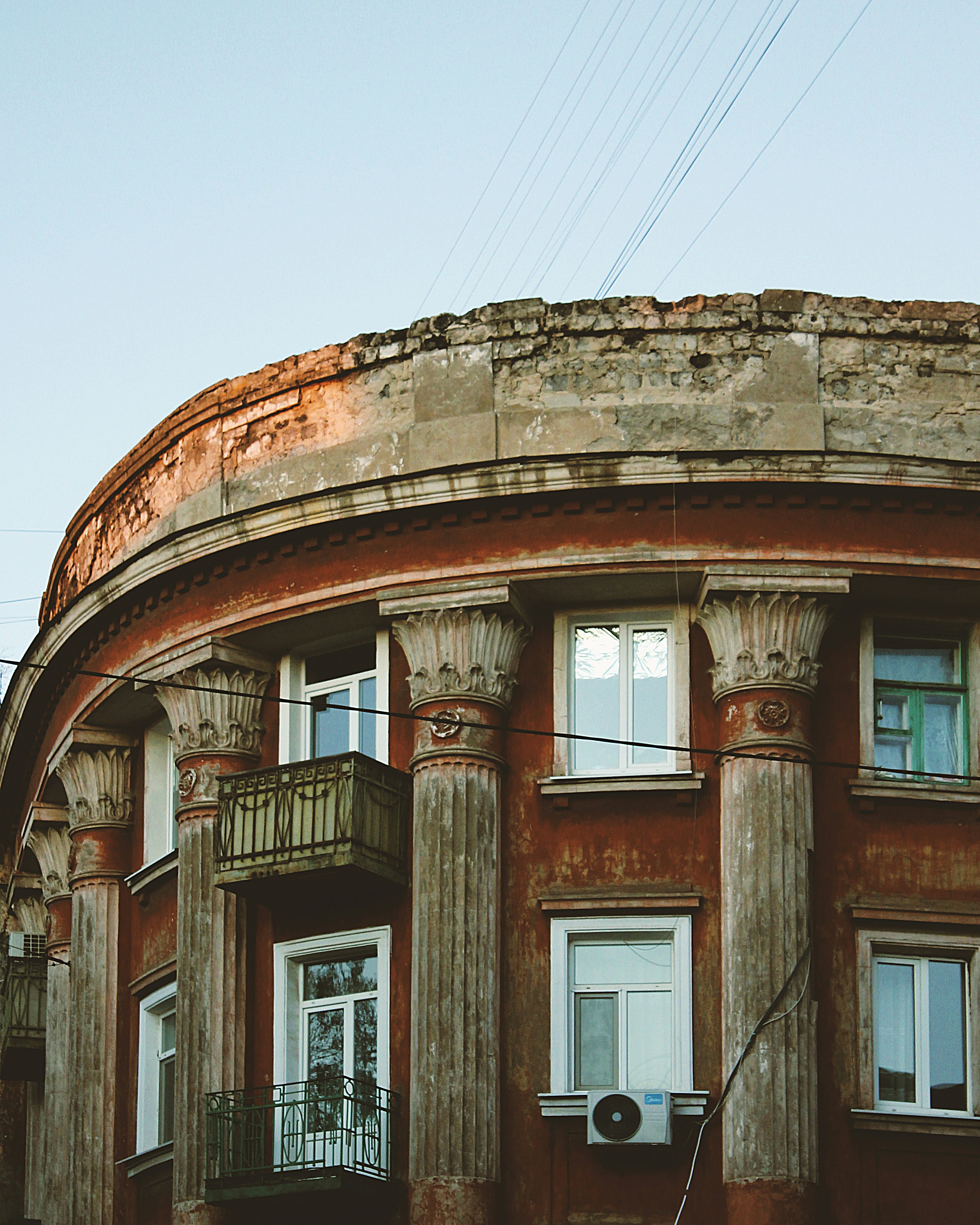 Curved Brick Corner: Ornate Columns and a Quiet Balcony