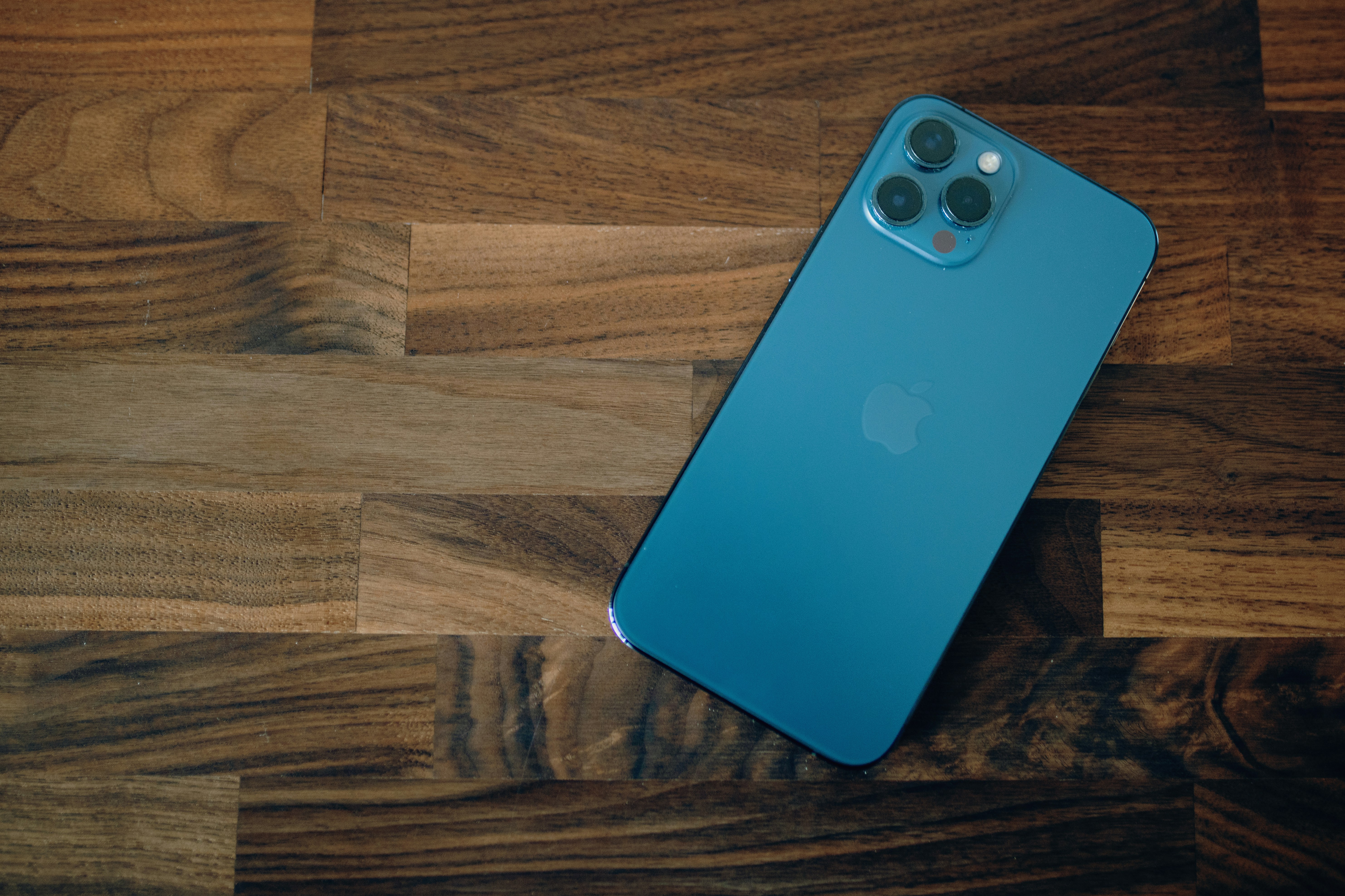 Foto Un primer plano de un iPhone azul sobre una superficie de madera – Imagen Azul gratis en ...