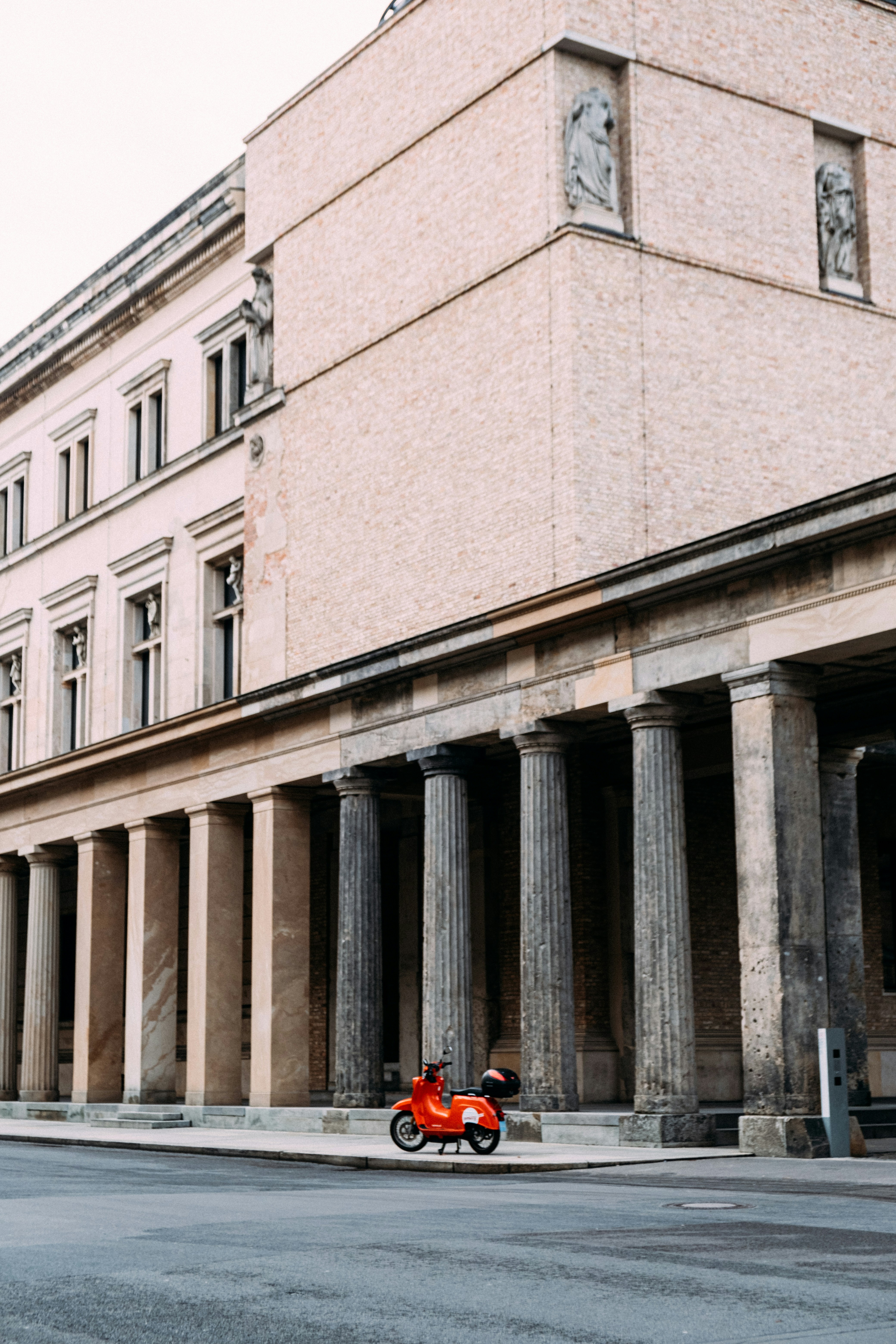 Red Vespa at the Foot of a Classical Colonnade