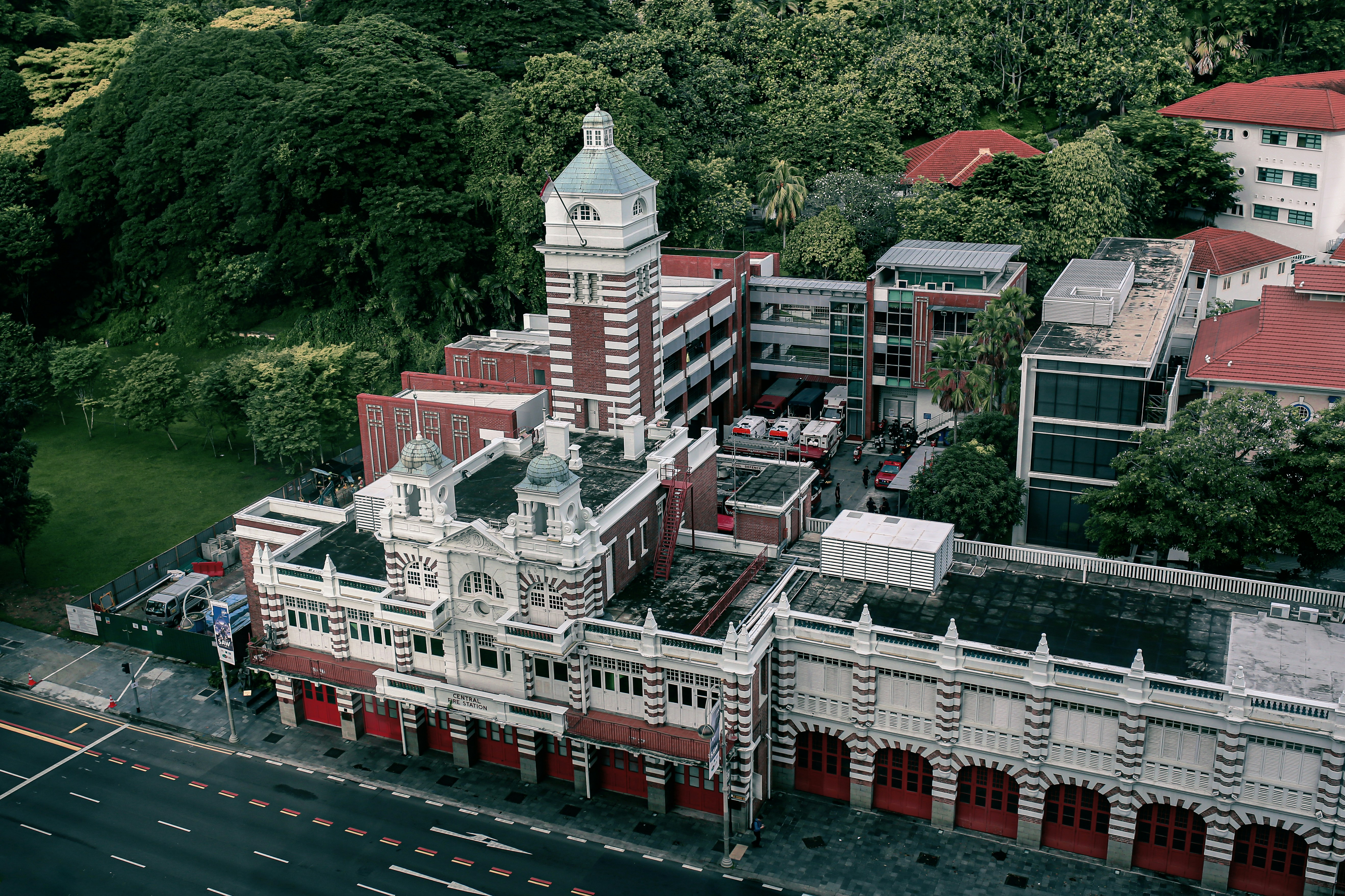 Historic building with ornate architecture juxtaposed against contemporary structures and lush greenery.