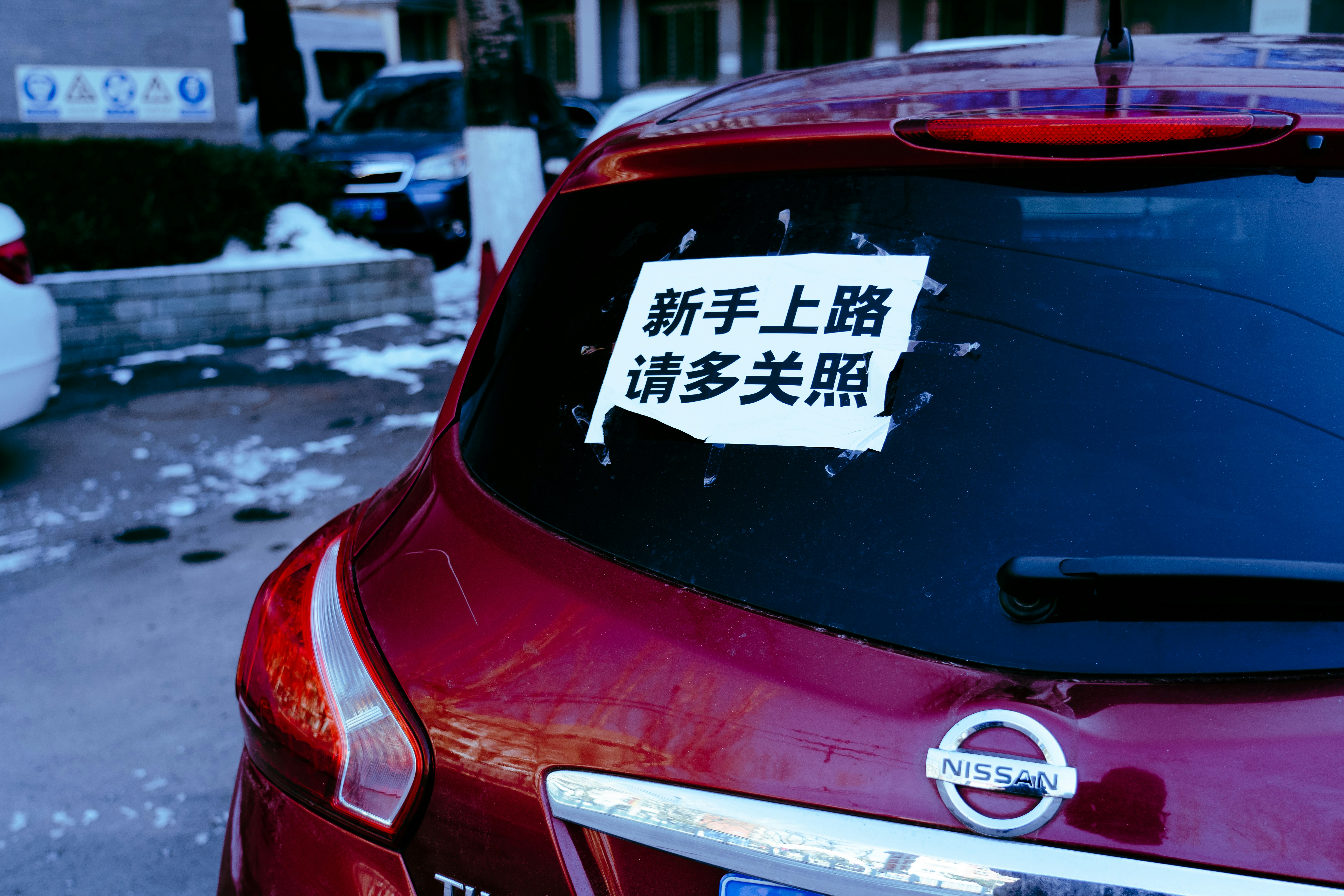 Note on the Rear Window: a Red Nissan in a Snow-Dusted Parking Lot