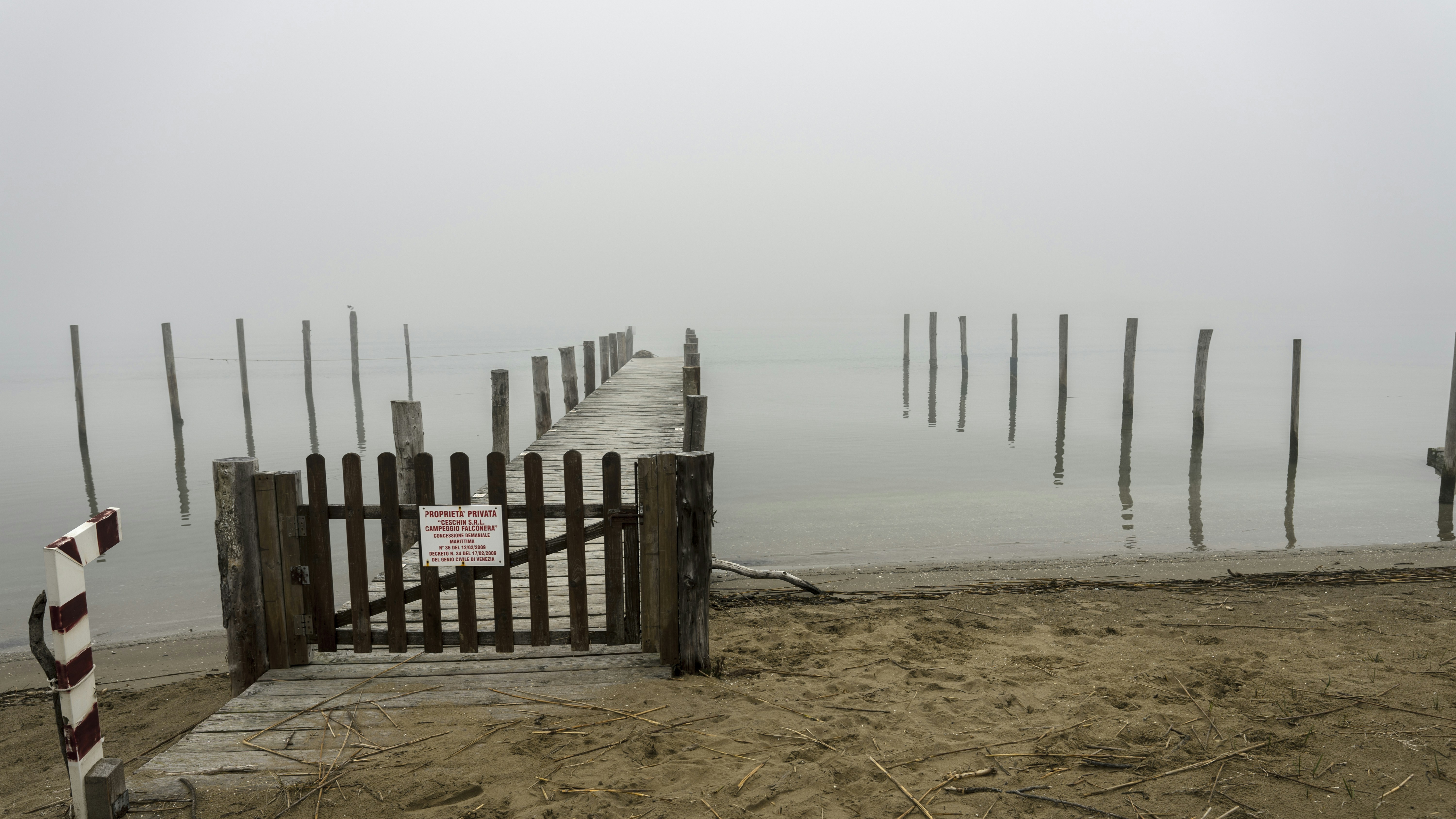 A wooden dock sitting on top of a sandy beach photo – Free Grey Image ...