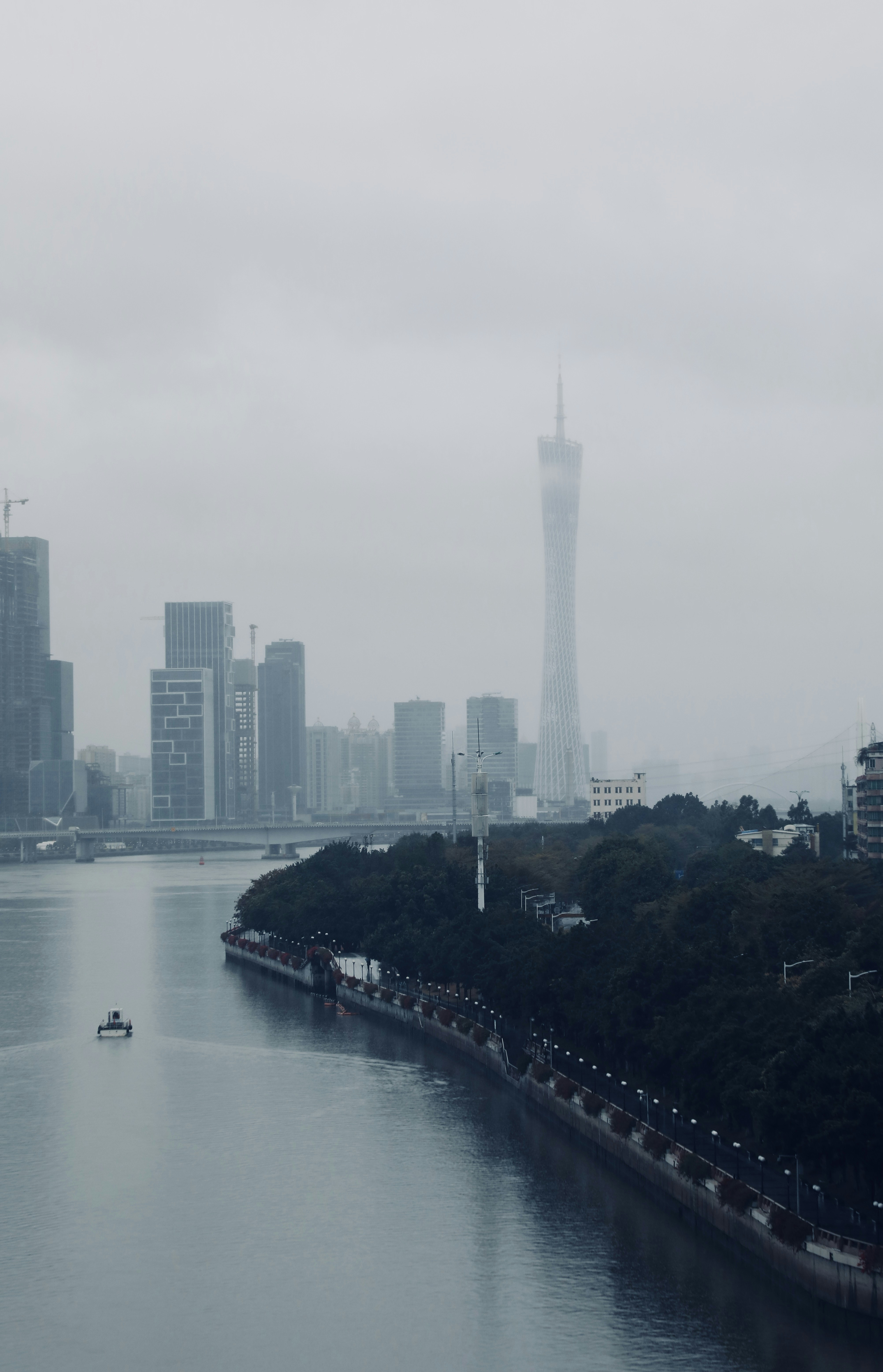 Mist-Laced Skyline: The Slender Tower Rising Over the Curving River