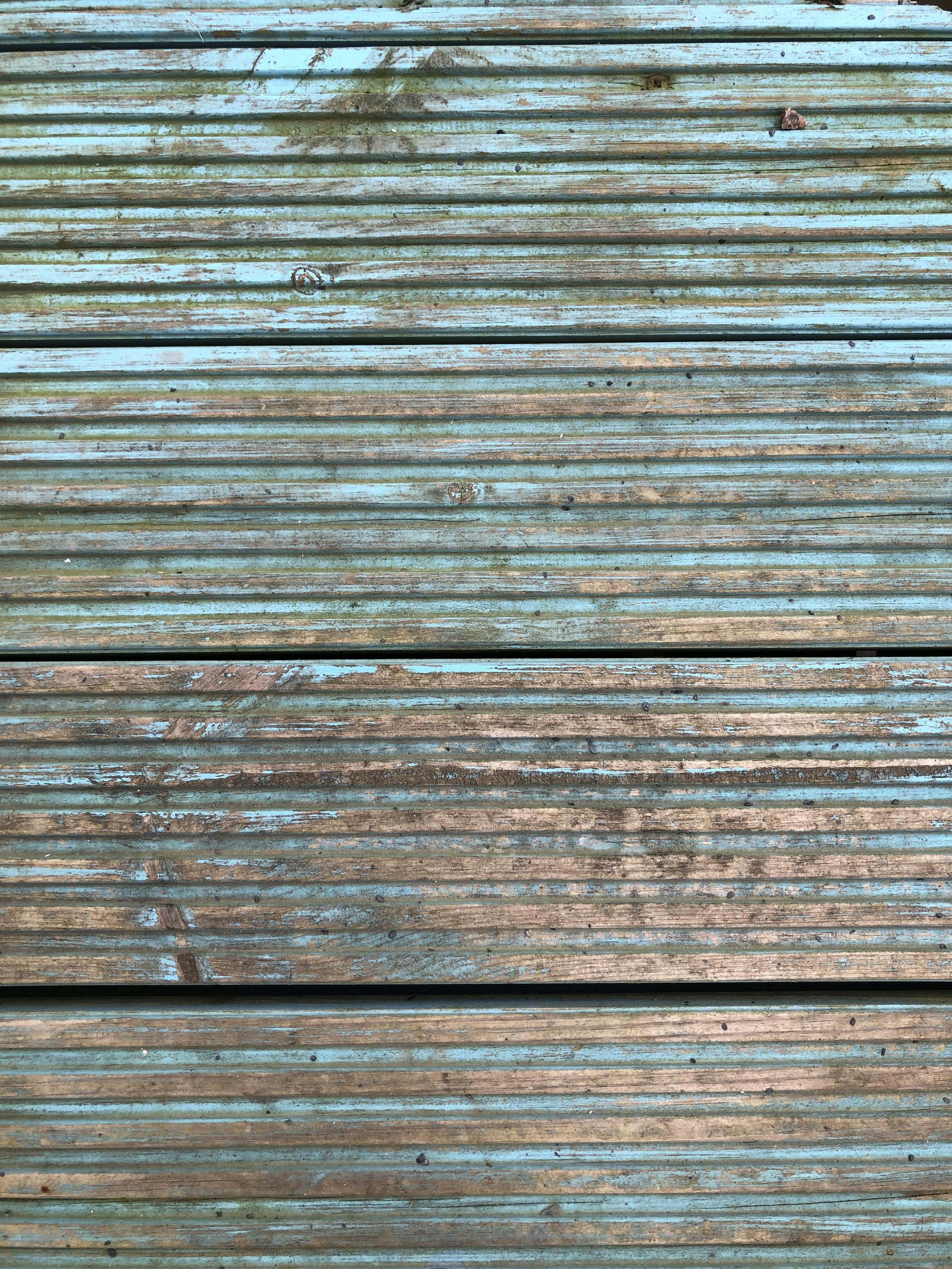 Textured wooden deck with a weathered blue finish, showcasing natural wear and character over time.