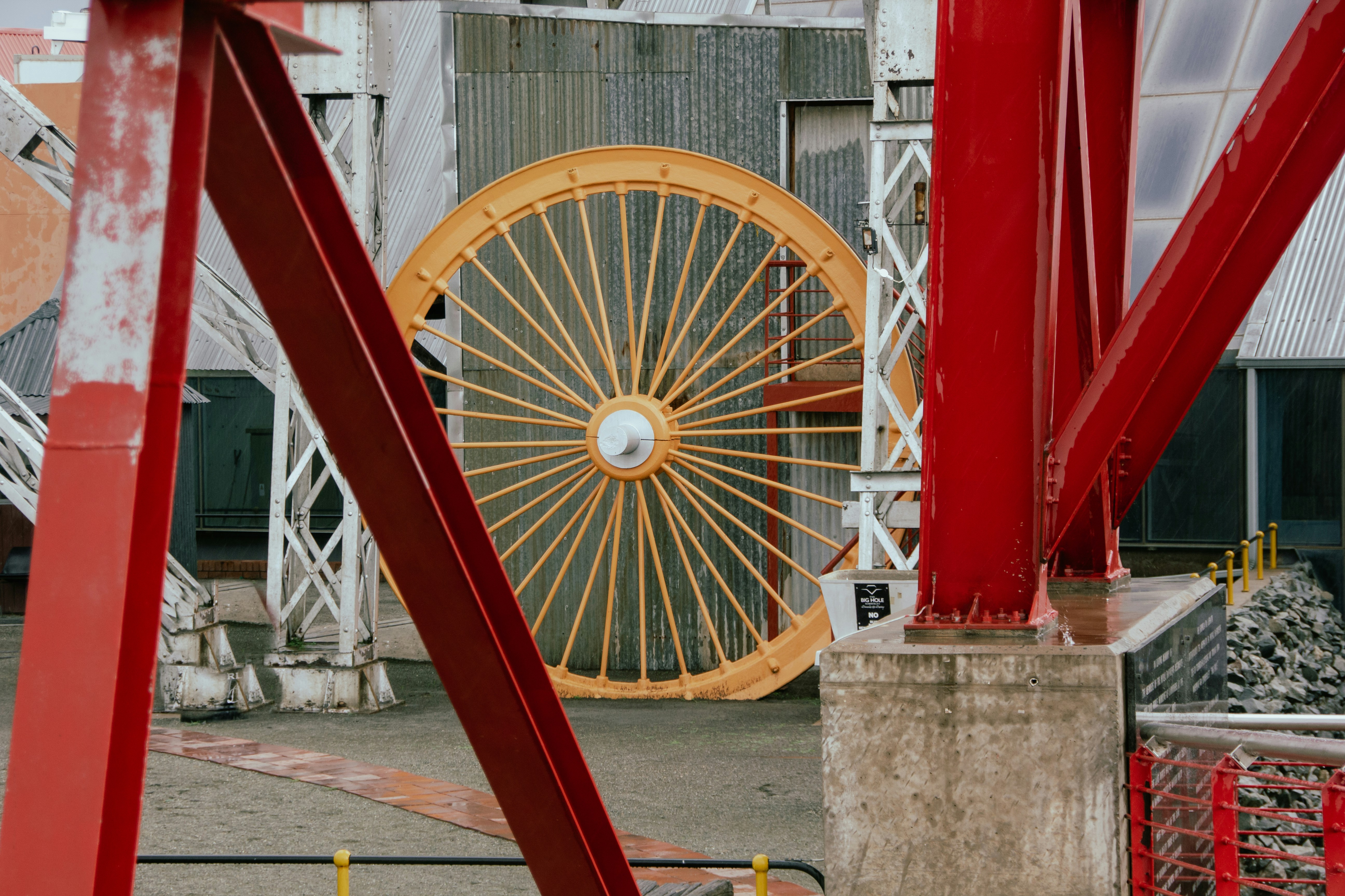 a large yellow and red wheel on display in front of a building
