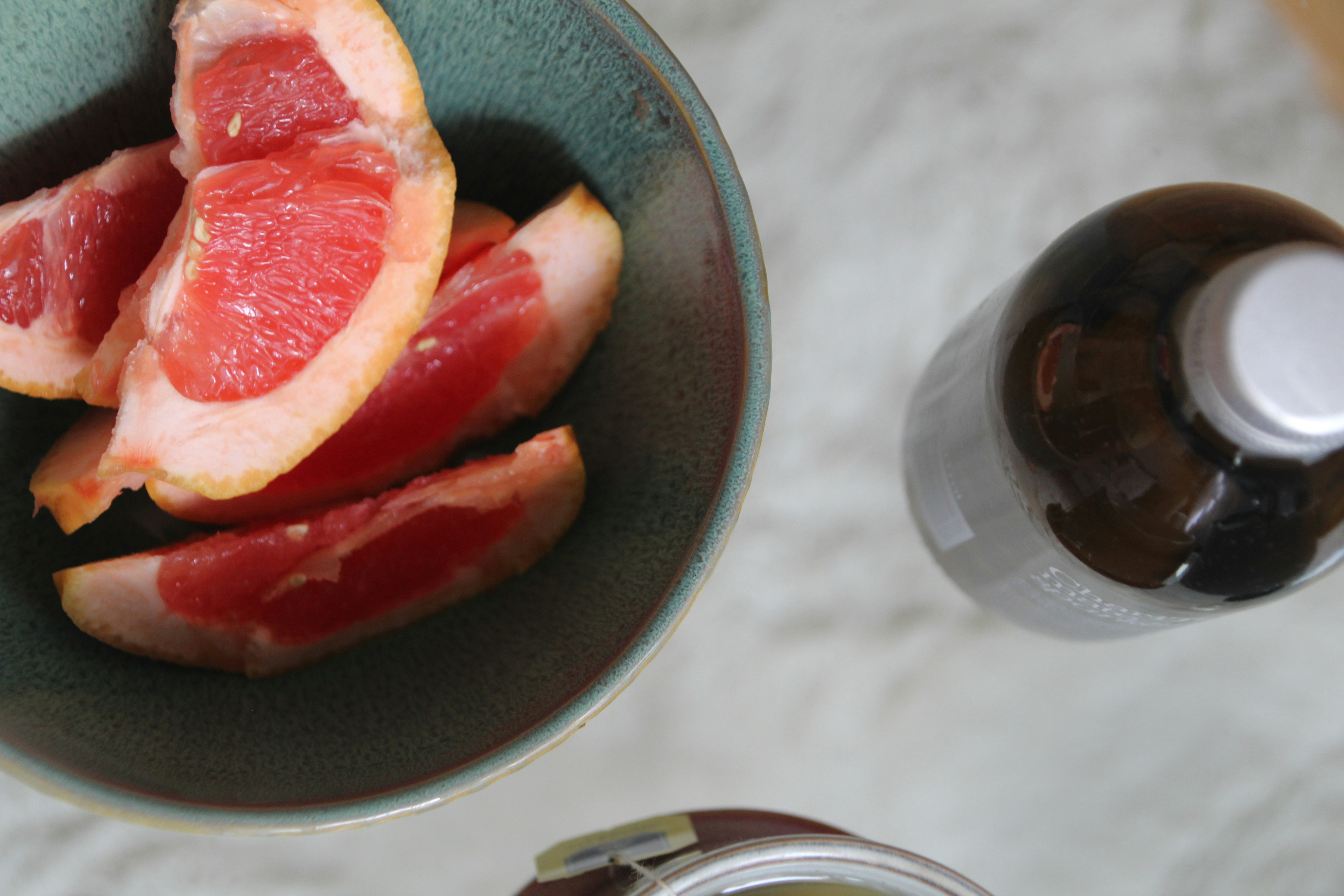 a bowl of blood oranges and a bottle of wine