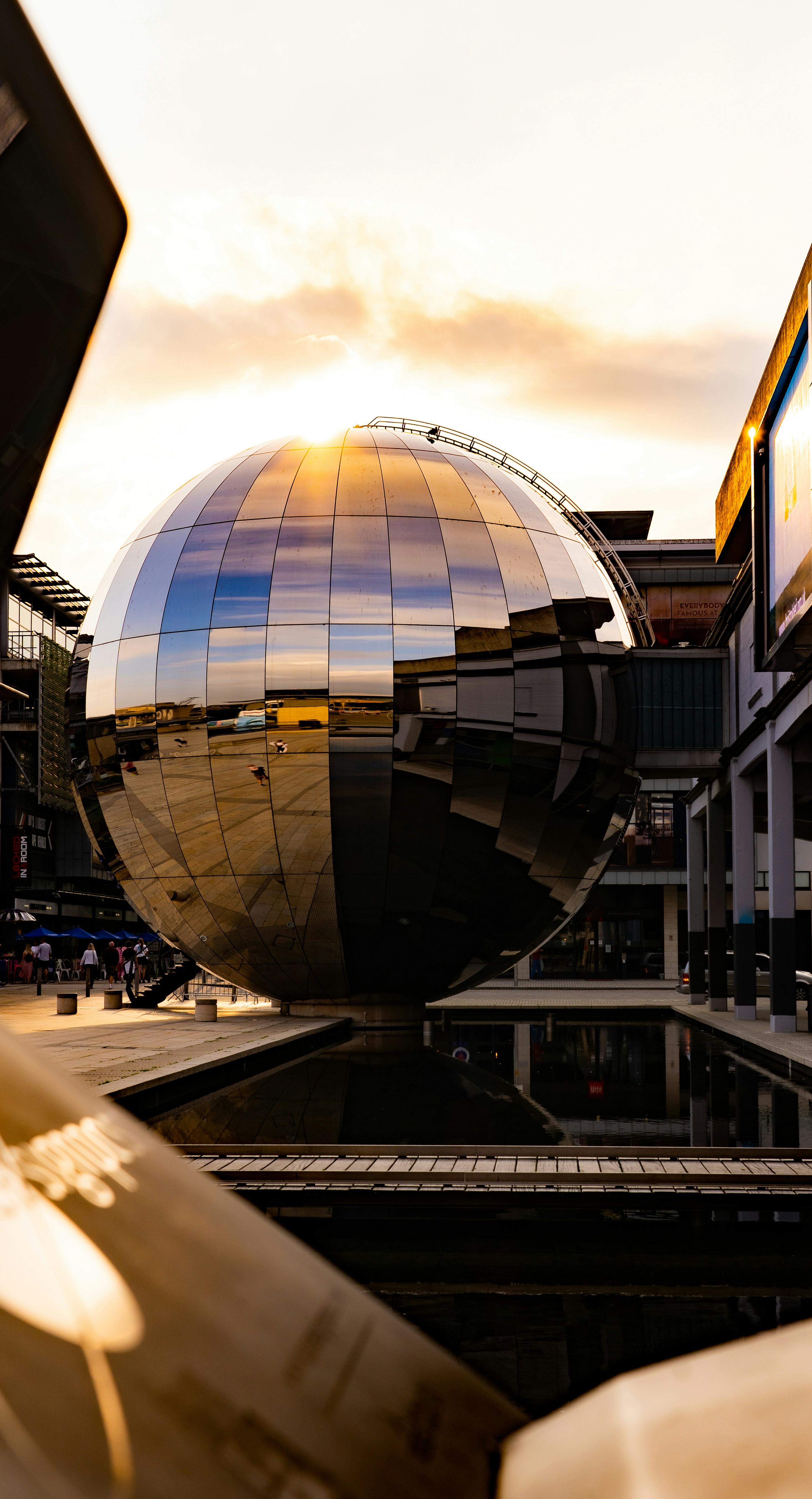 a large metal sphere sitting in the middle of a street
