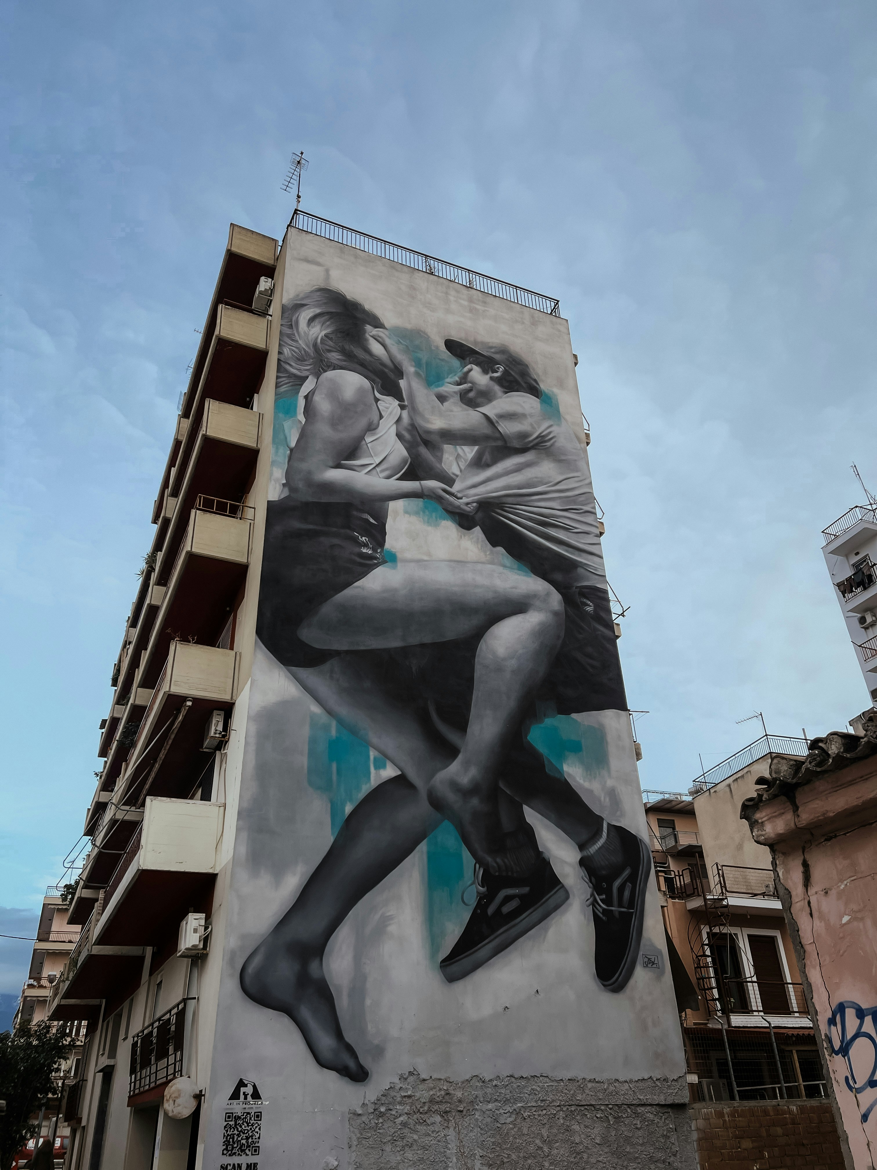 Urban mural duel: a dancer and a sprinter suspended on concrete canvas