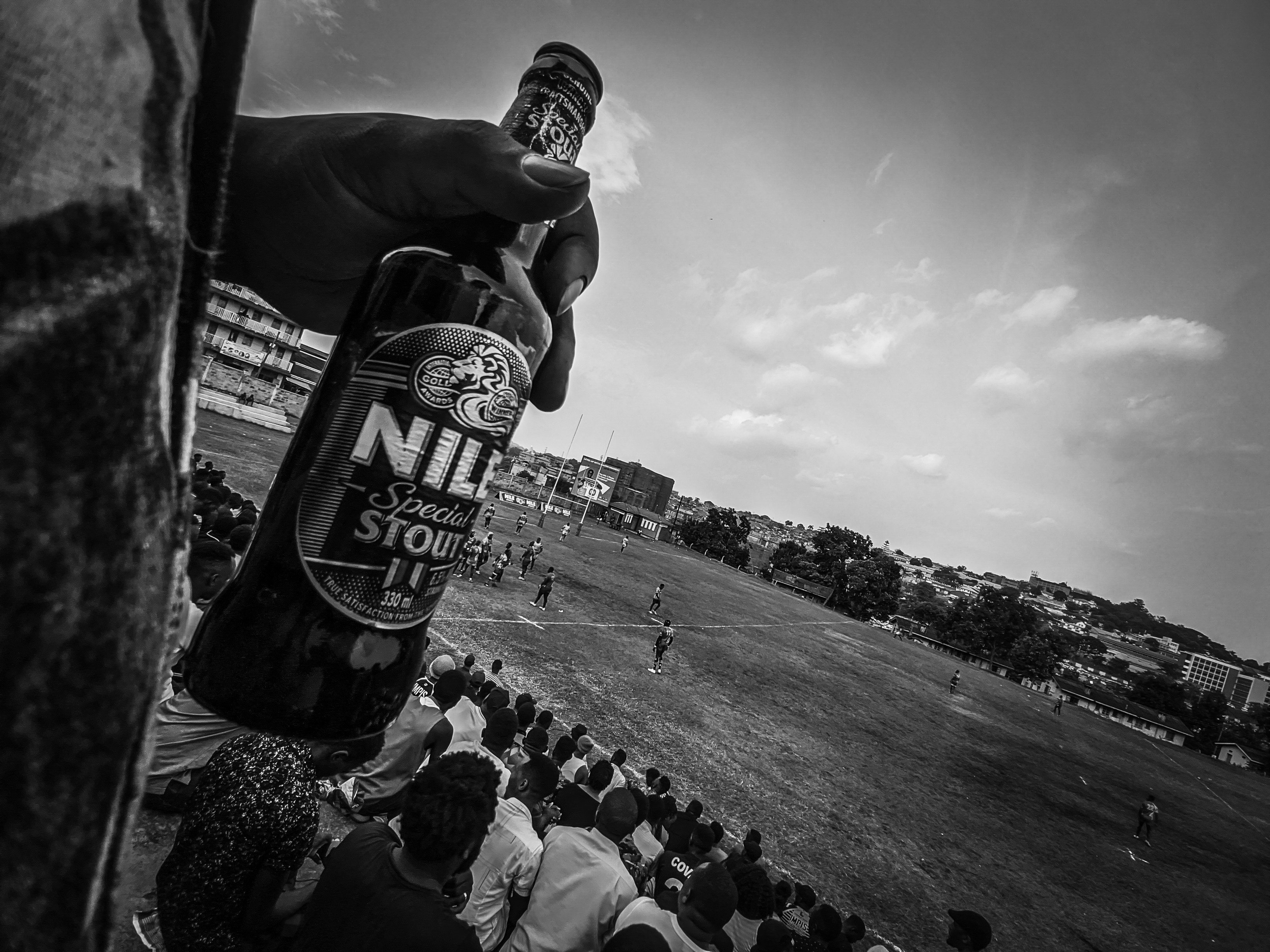 Front-Row Bottle in Hand: A Crowd-Filled Field from a Low Angle