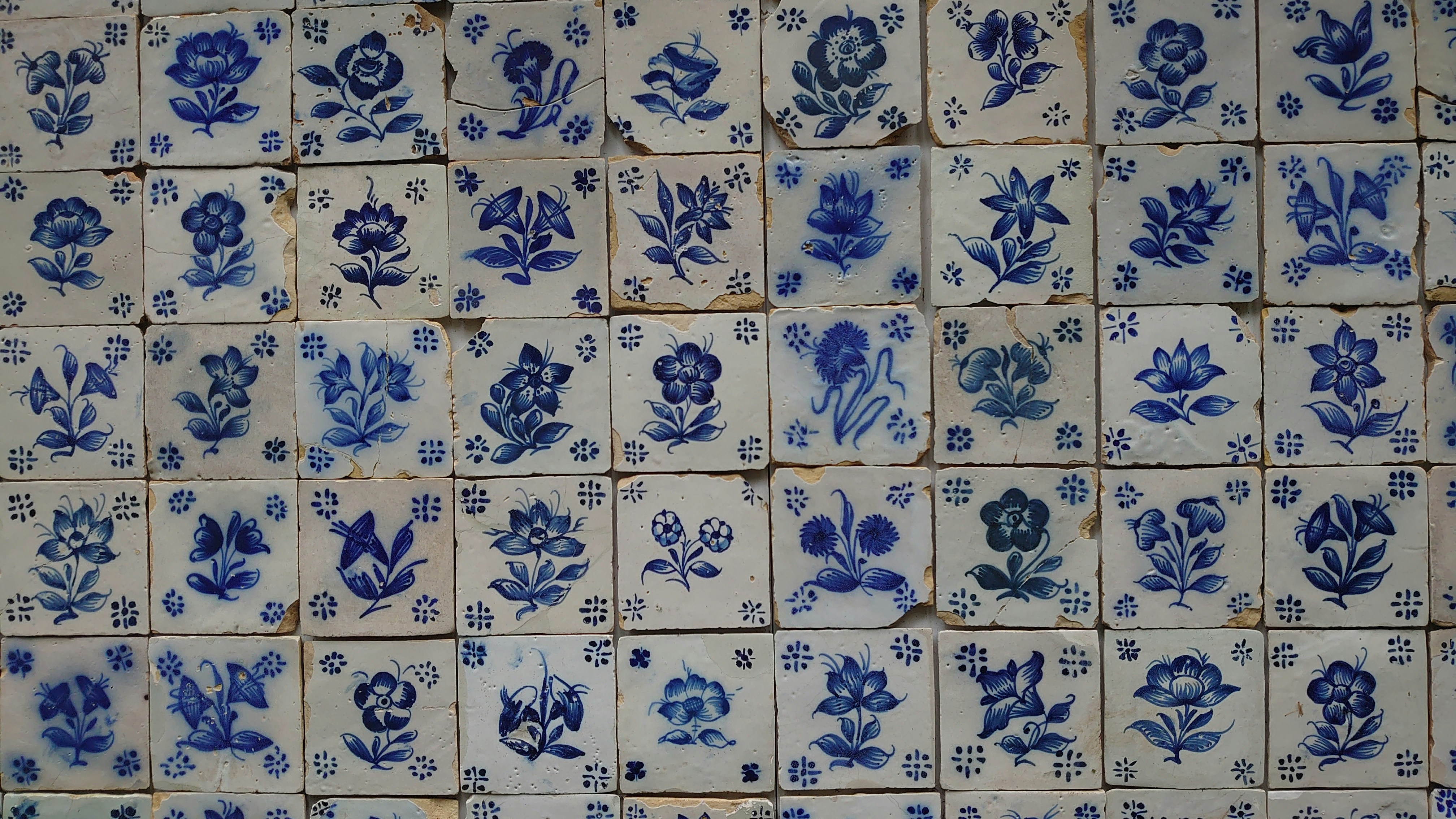 A blue and white tile wall with flowers on it photo – Free Grey Image ...