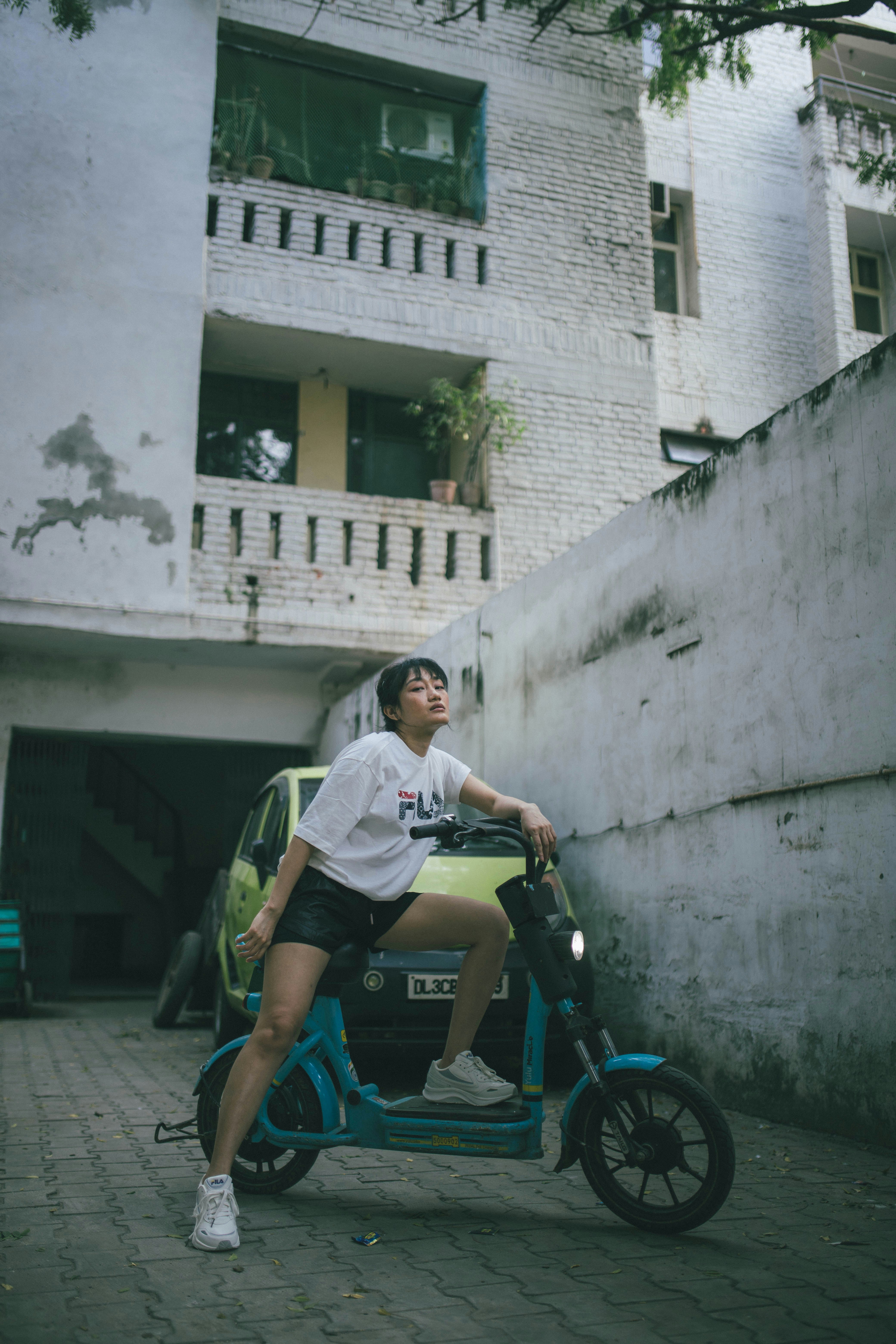 a woman sitting on a scooter in front of a building