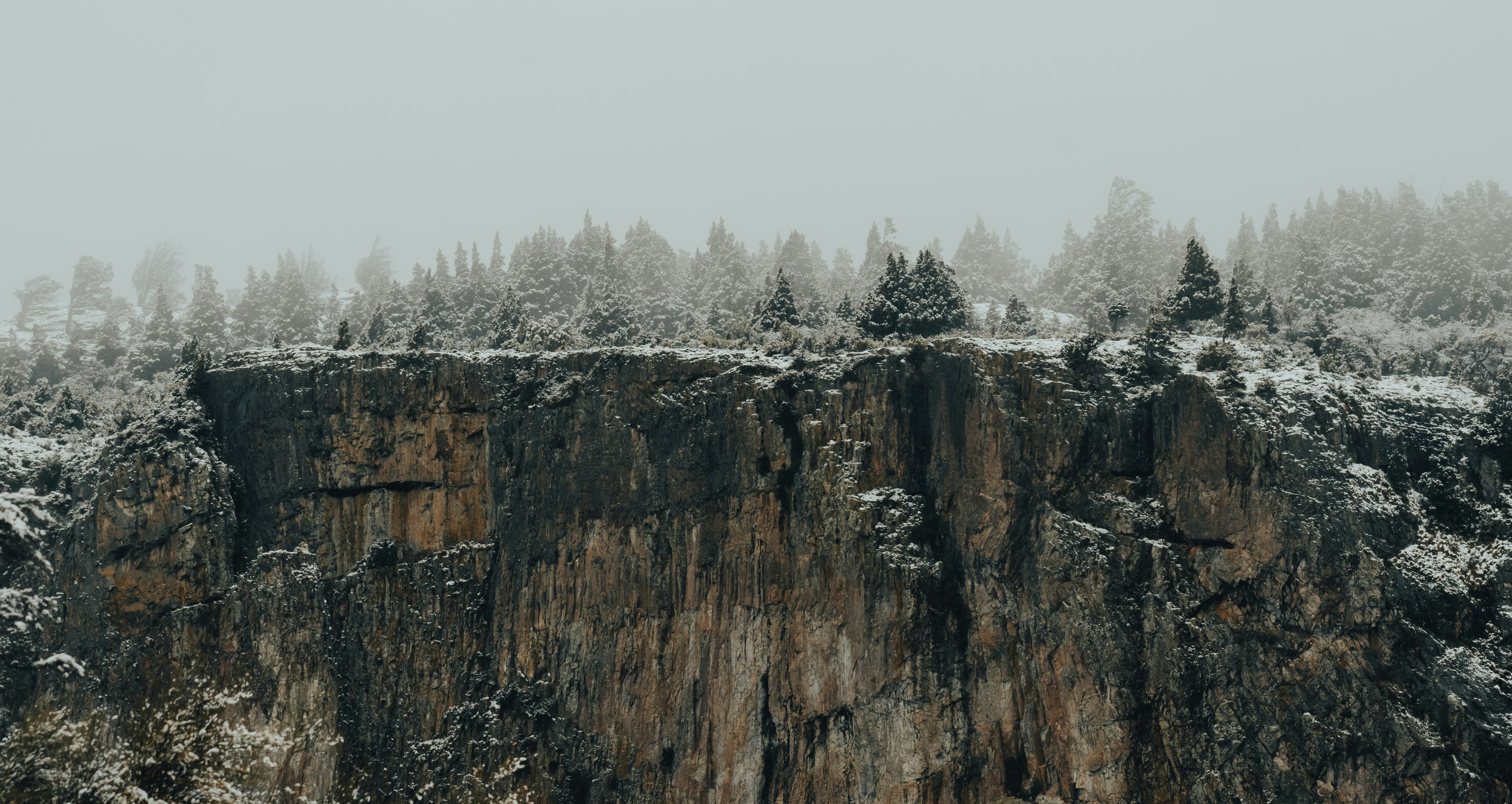 Snow-Outlined Cliff Edge Under a Quiet Winter Sky