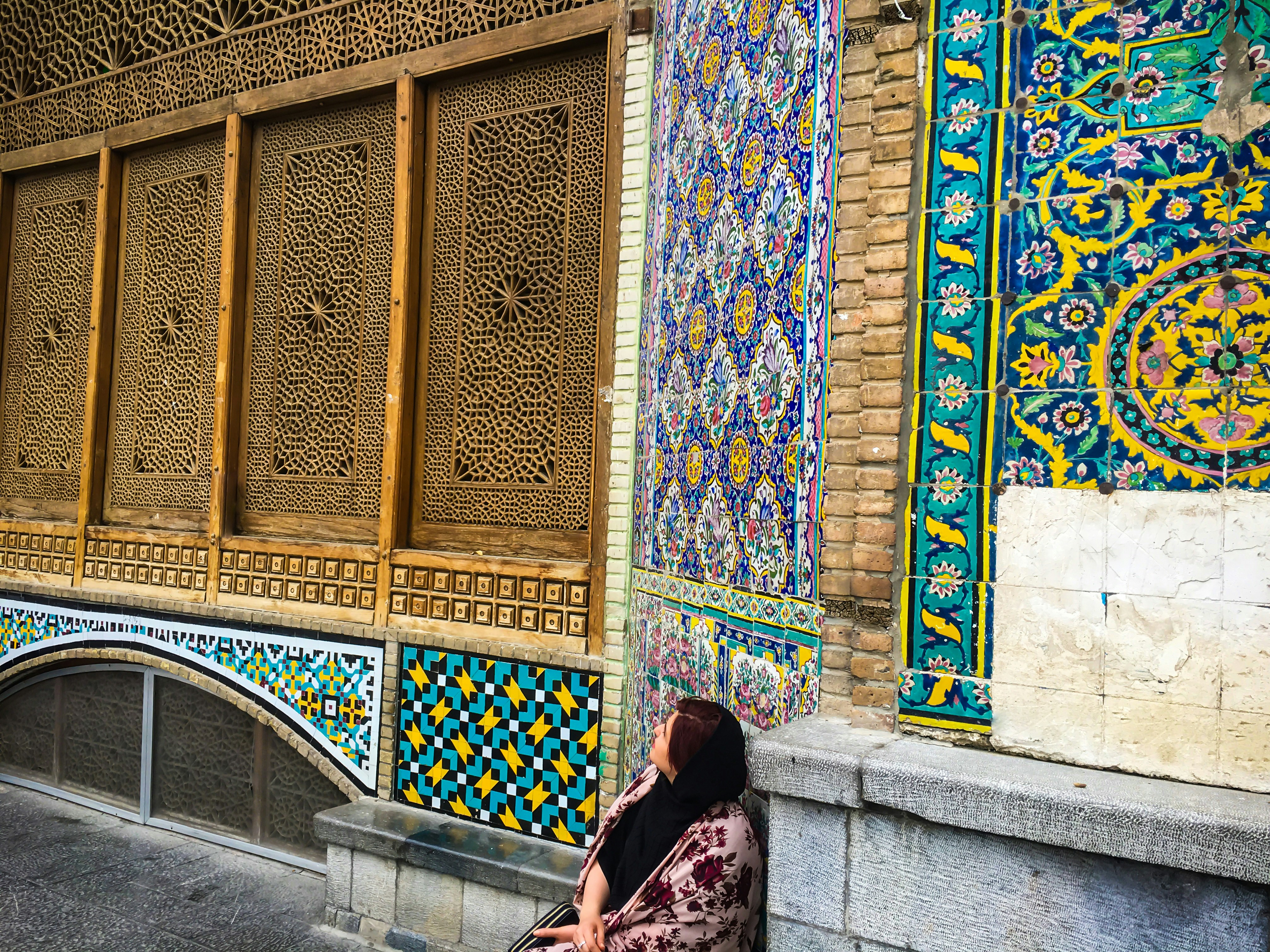 a woman sitting on a bench in front of a building